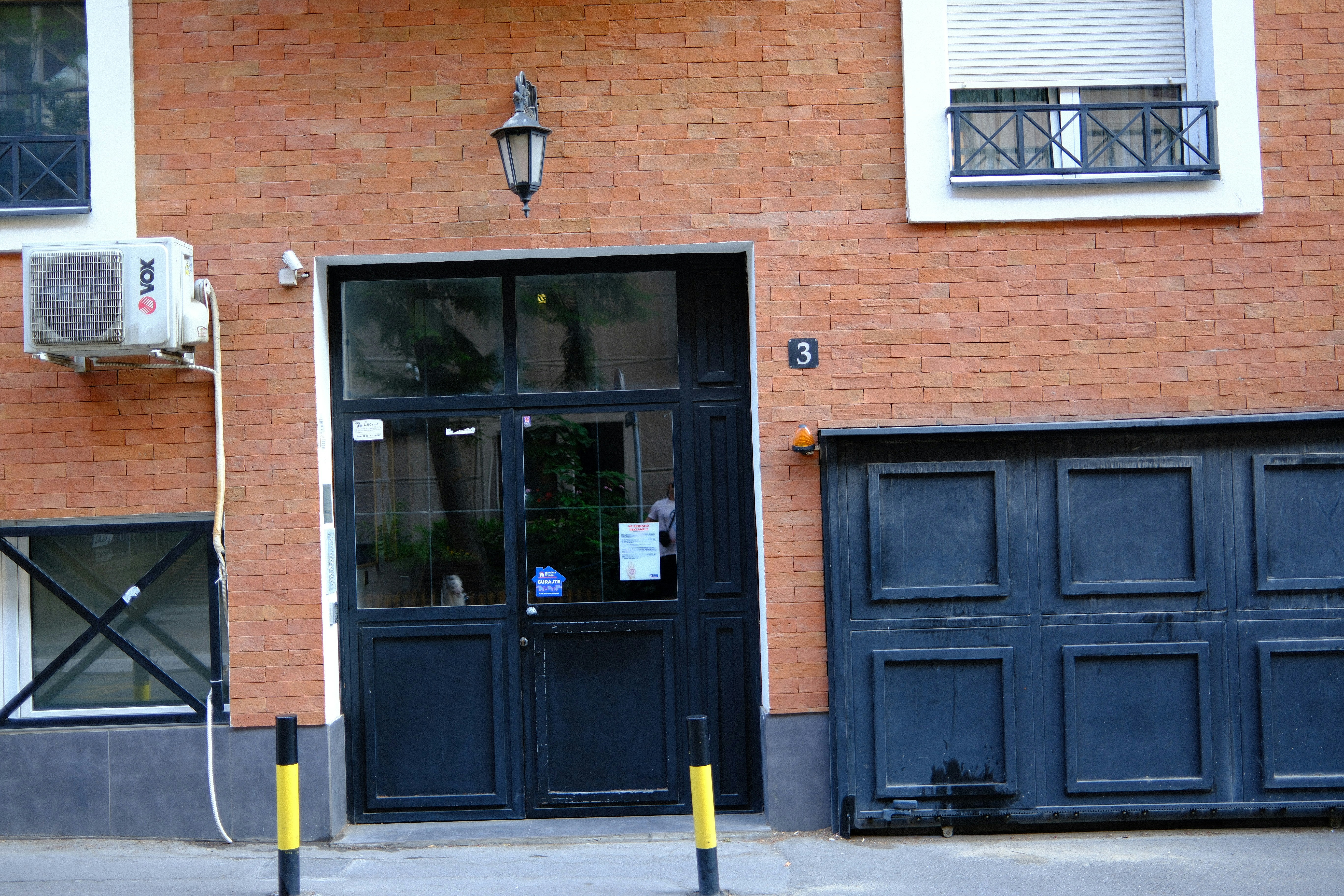 Dark doorway on a brick façade under a hanging lantern