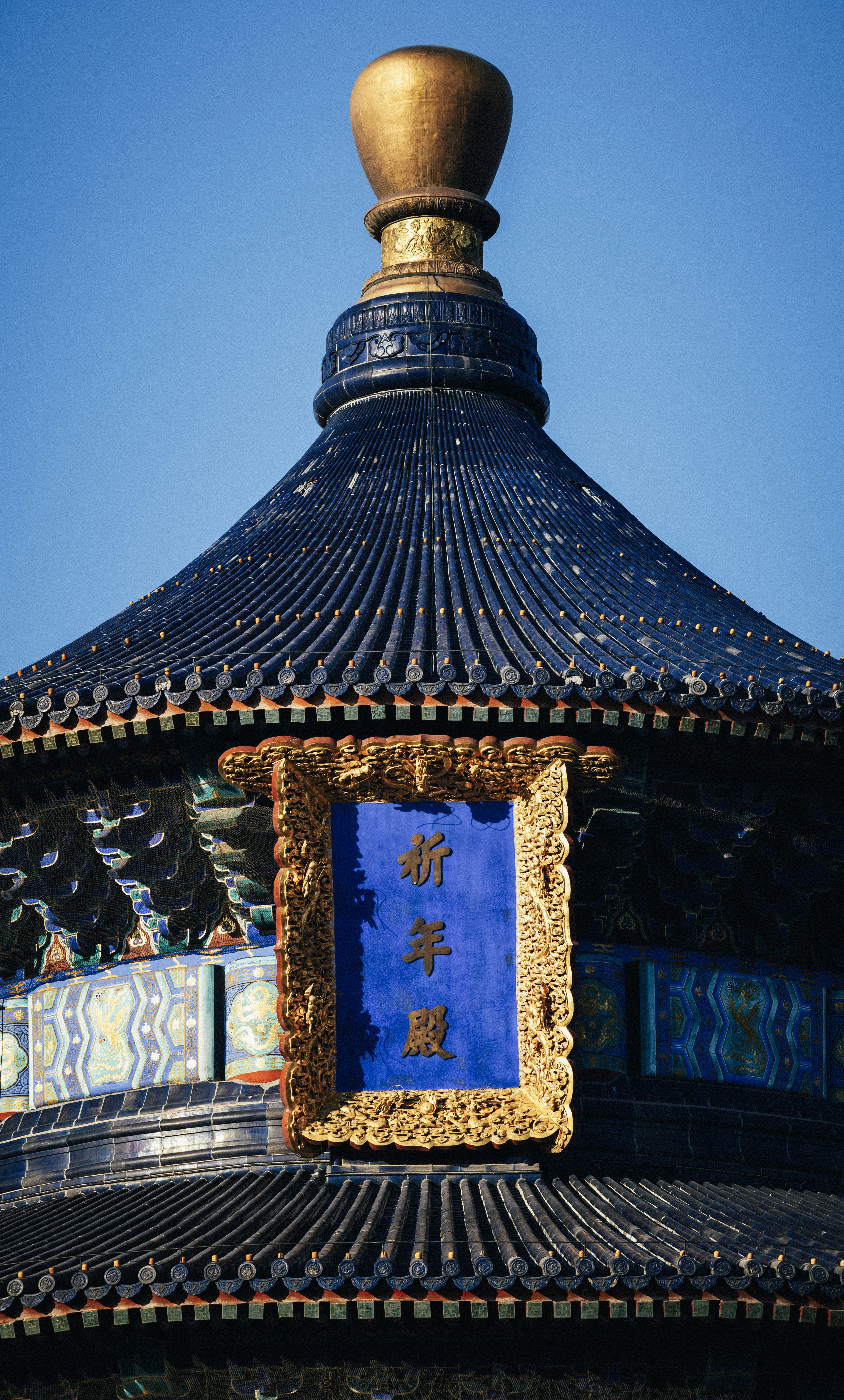 Blue Plaque on the Temple Roof: An Ornate Finial Scene