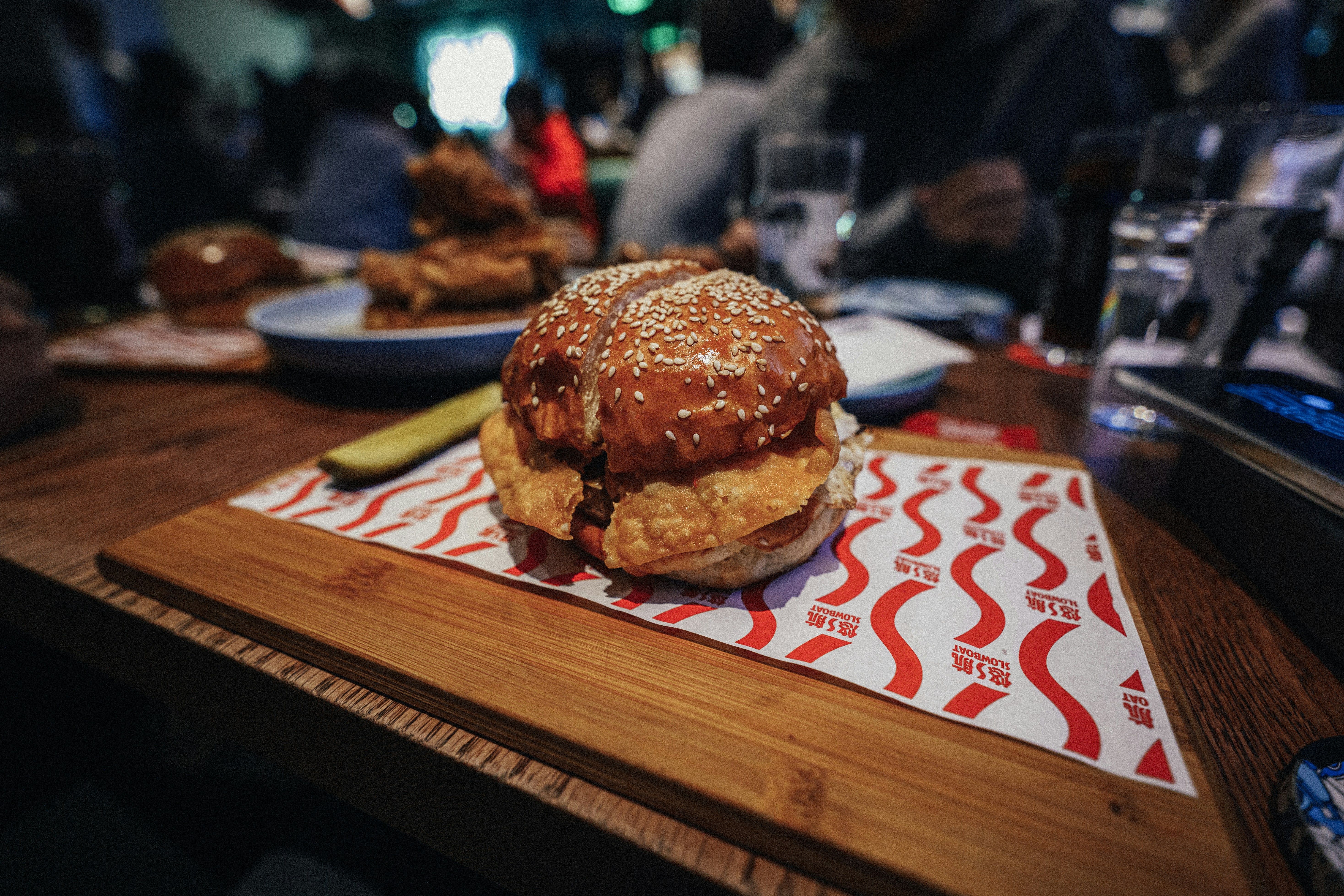 Sesame Bun Centerpiece: Crunchy Fried Chicken Burger on a Patterned Board