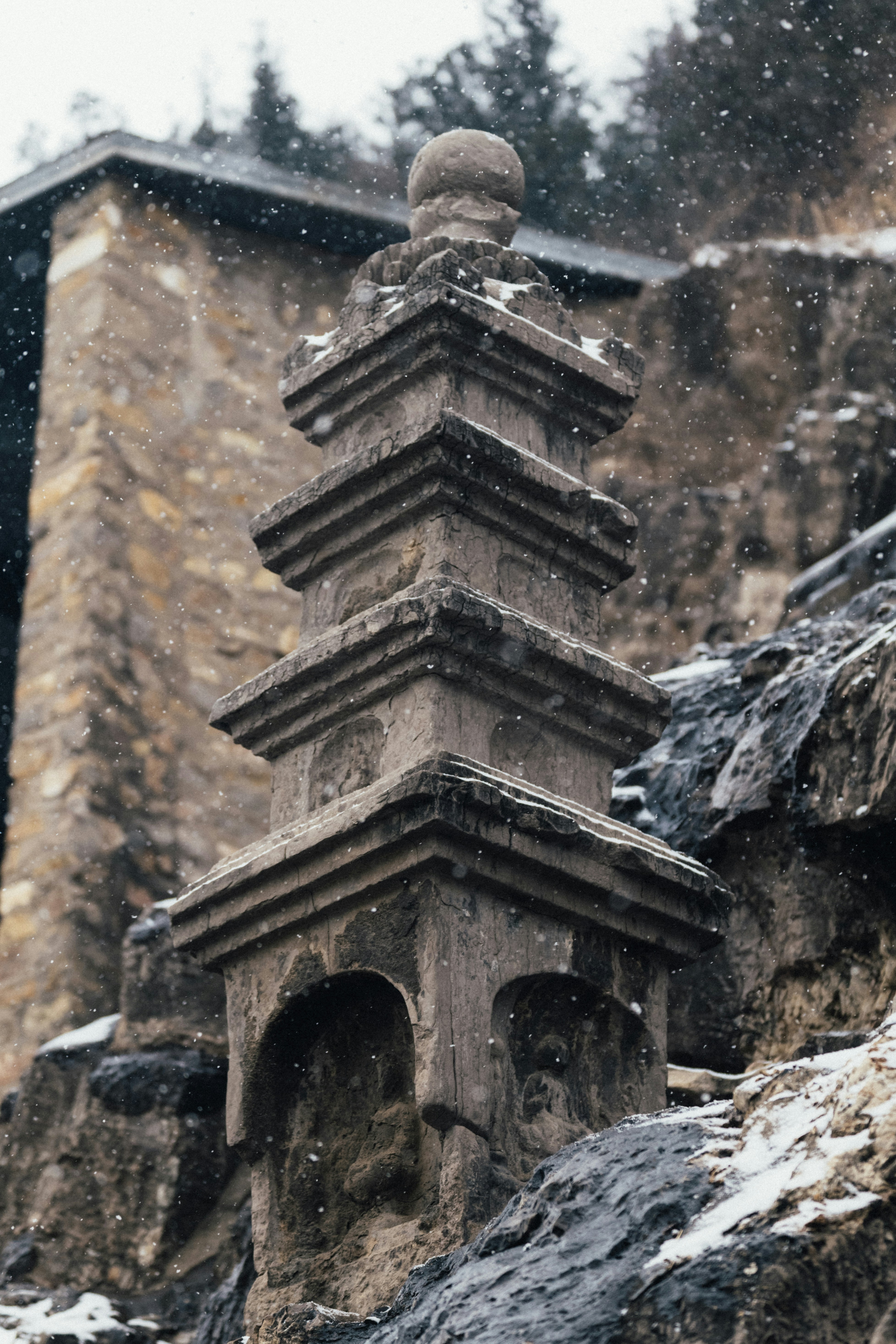 Snowy Stone Pagoda Rising Above Rugged Cliffside