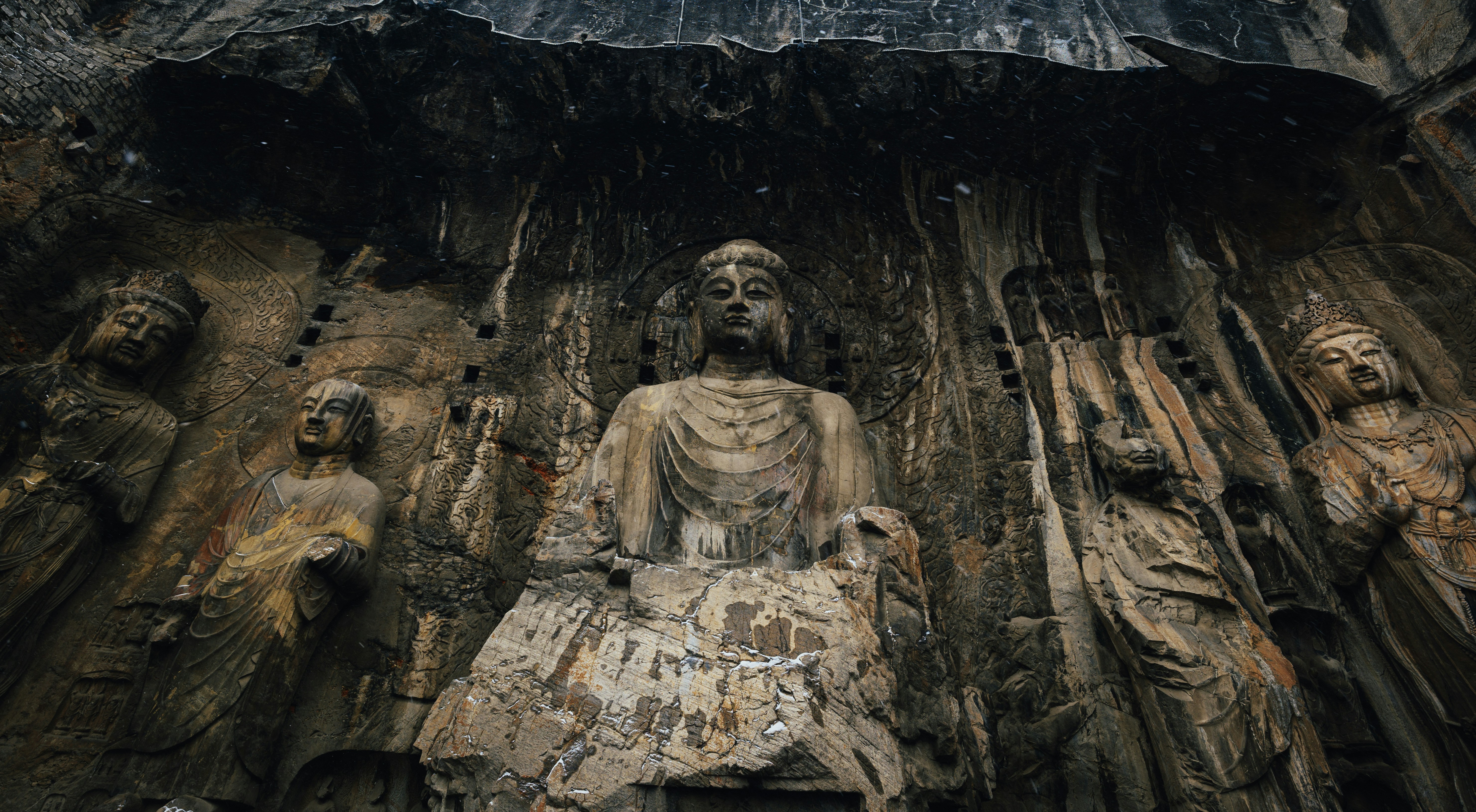 Weathered Carved Guardian: A Row of Silent Buddhas Beneath a Crumbling Arch