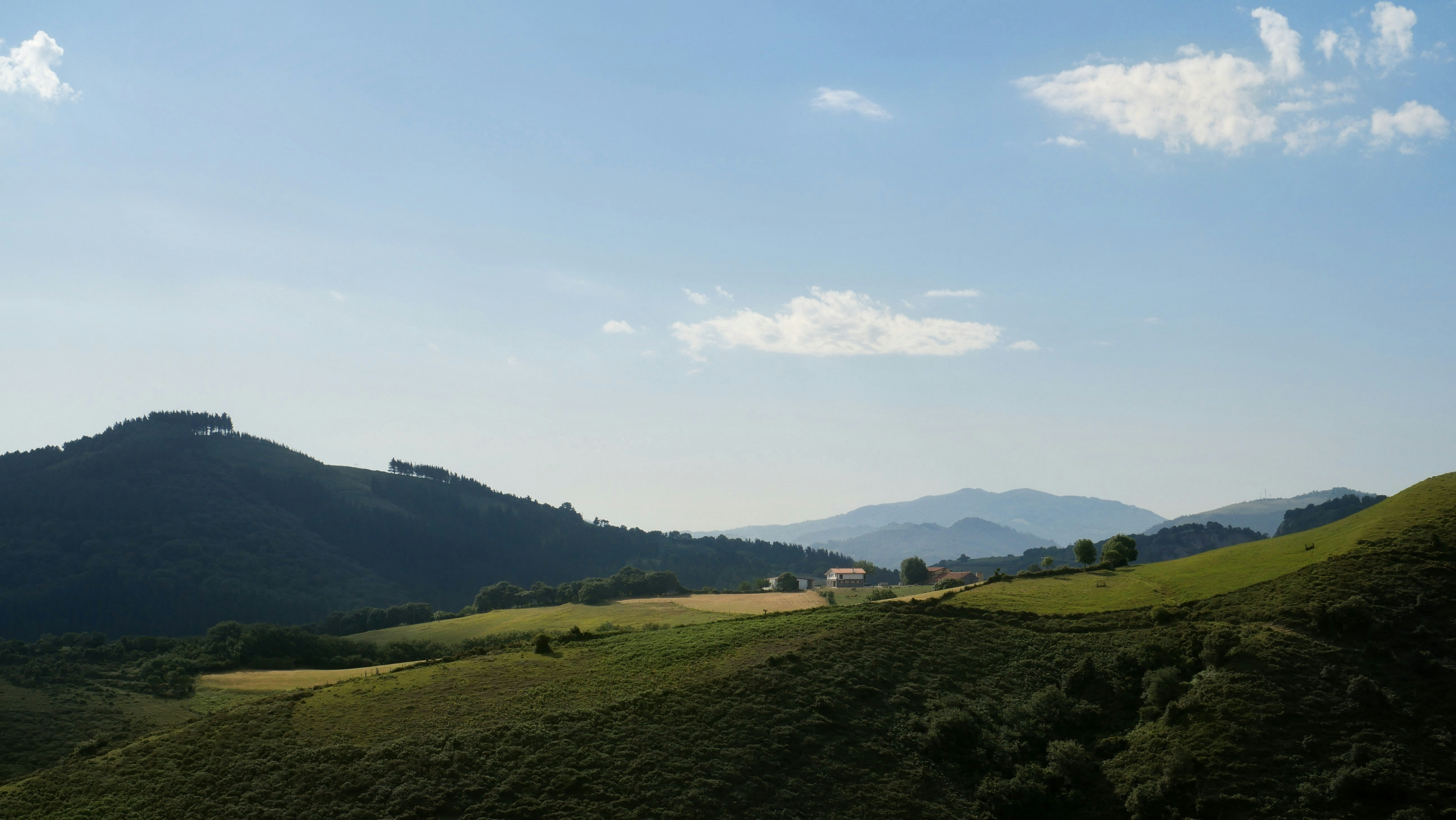Rolling Valleys under a Clear Day: Light, Hills, and Distant Ridge