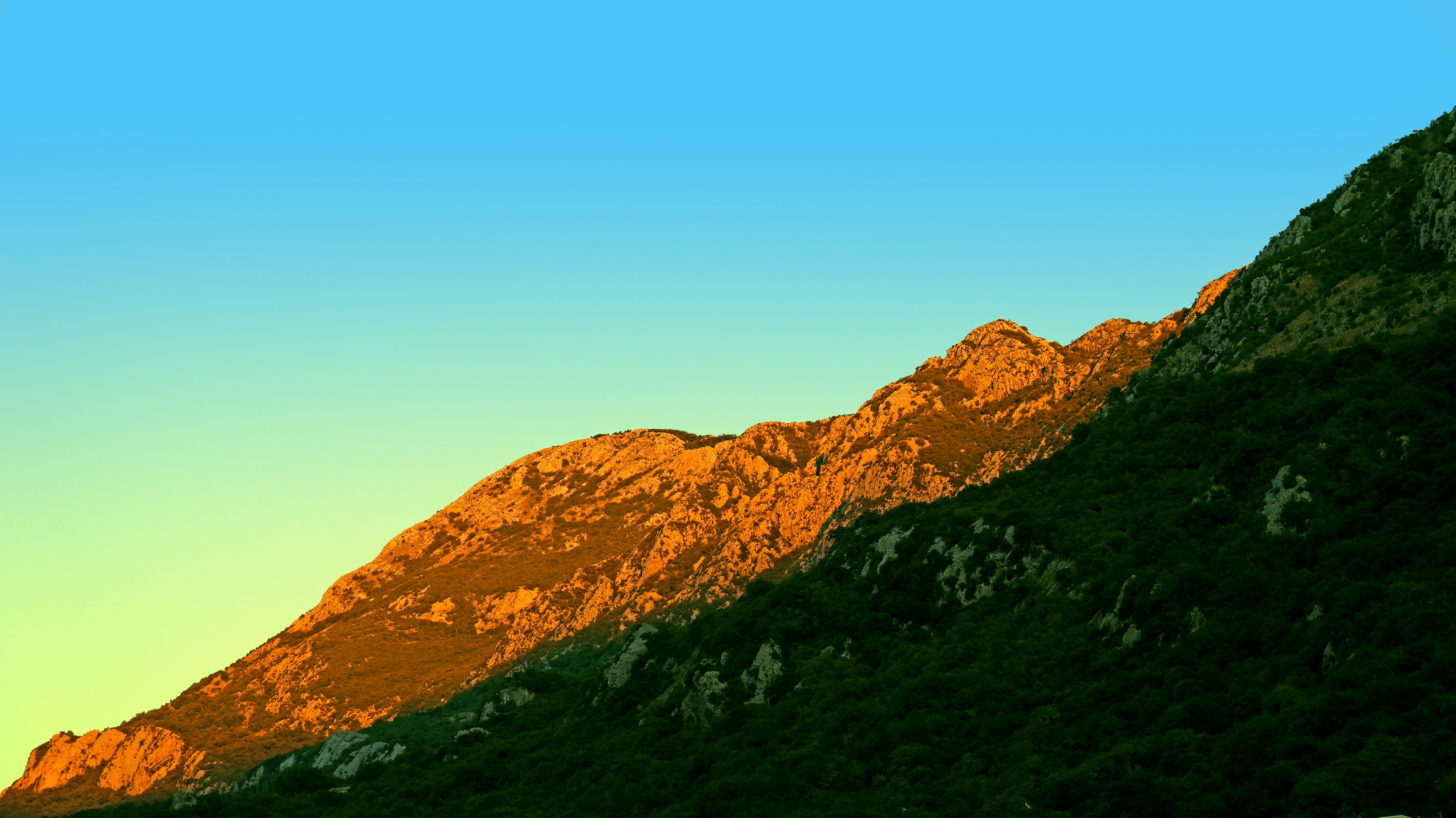Sunlit Ridge: Golden Peaks Along a Clear Sky