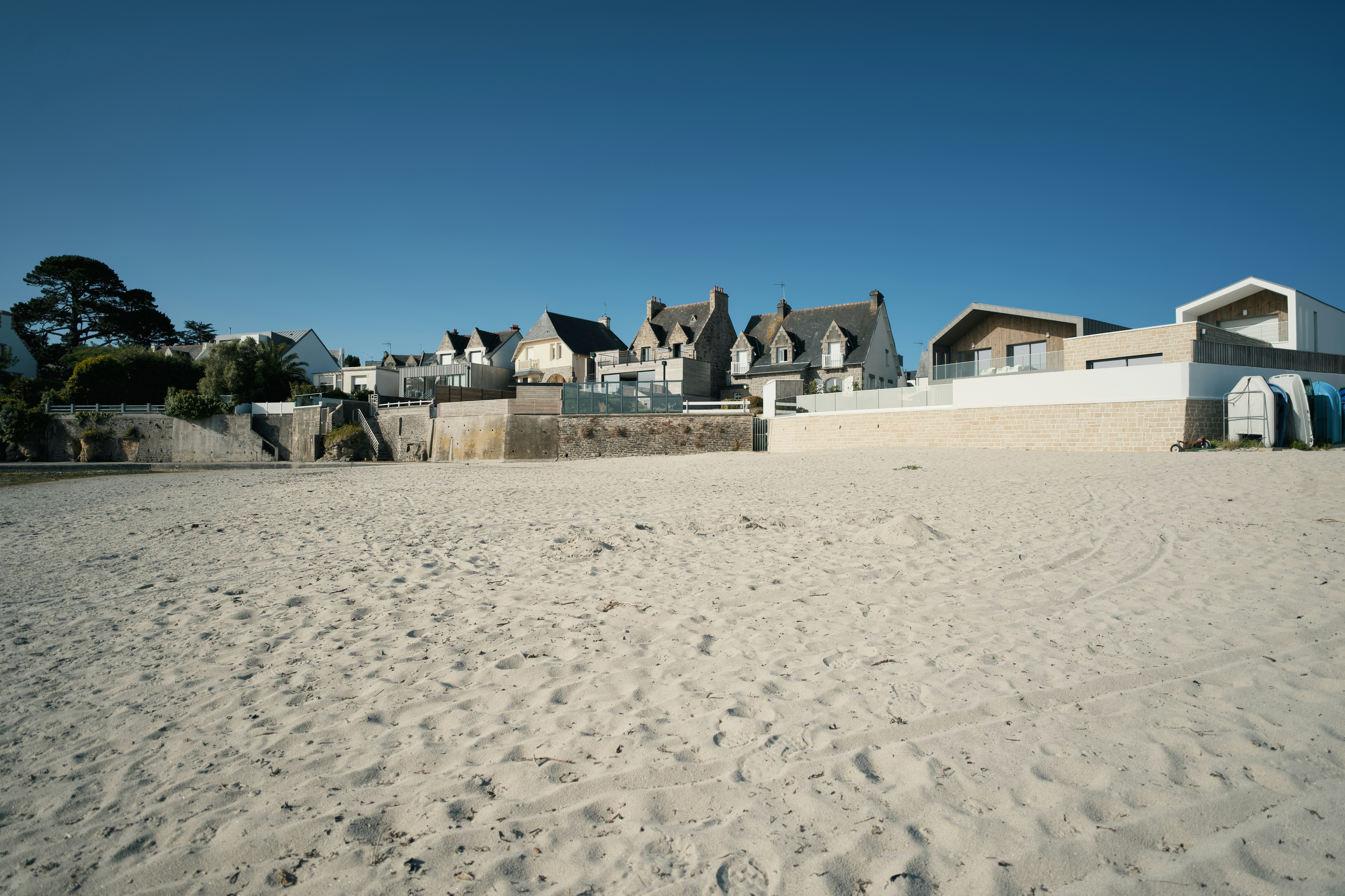 Coastal Dunes and Row of Seaside Cottages Under a Clear Sky