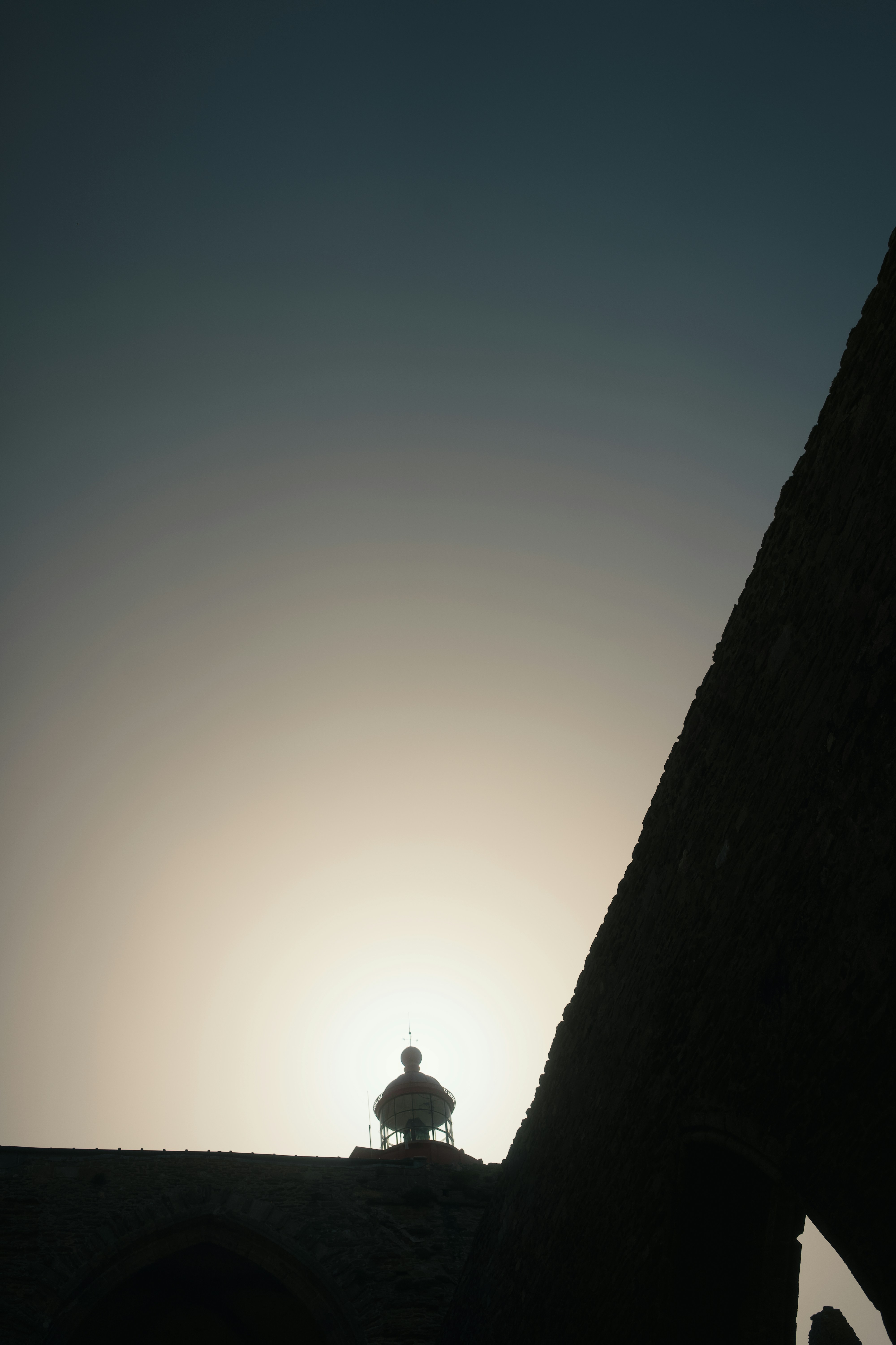 Silhouette Over the Sunlit Skyline: A Dome Crest Beneath Architectural Arches