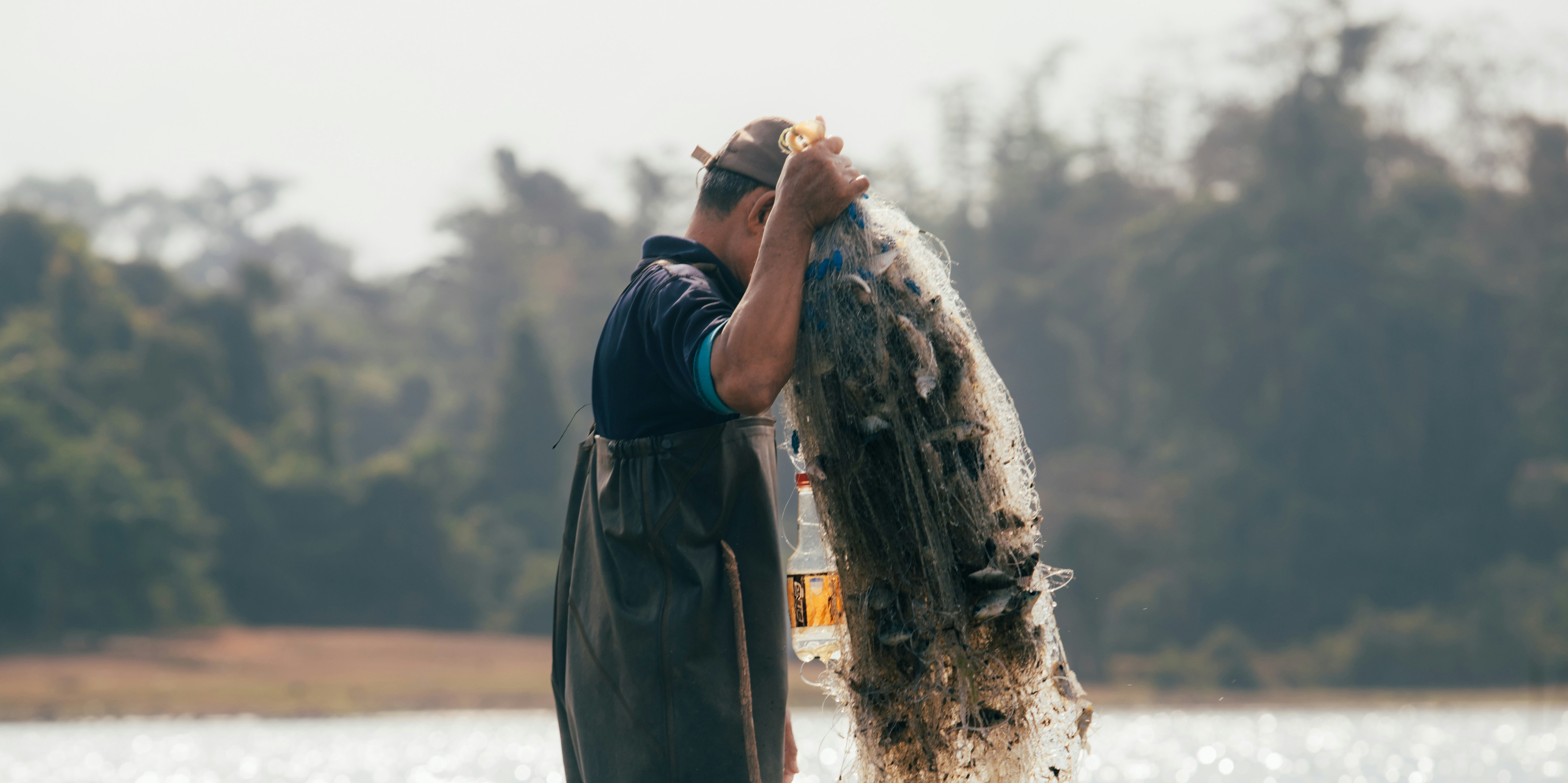 Handshake at Dusk: A Fisherman and his Catch by the Riverbank
