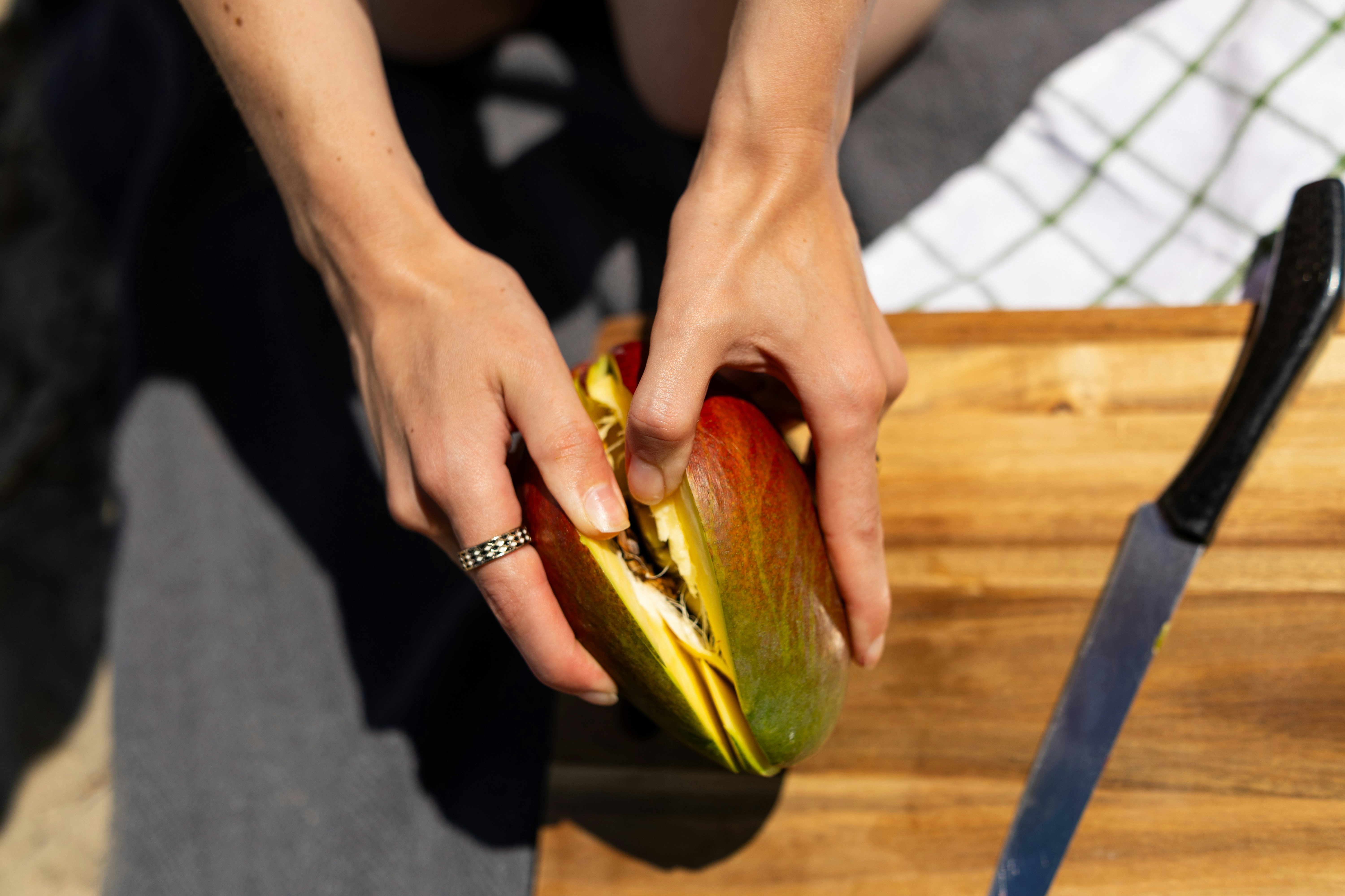Citrus Slices Meet a Sharp Edge: Hands at a Wooden Prep Board
