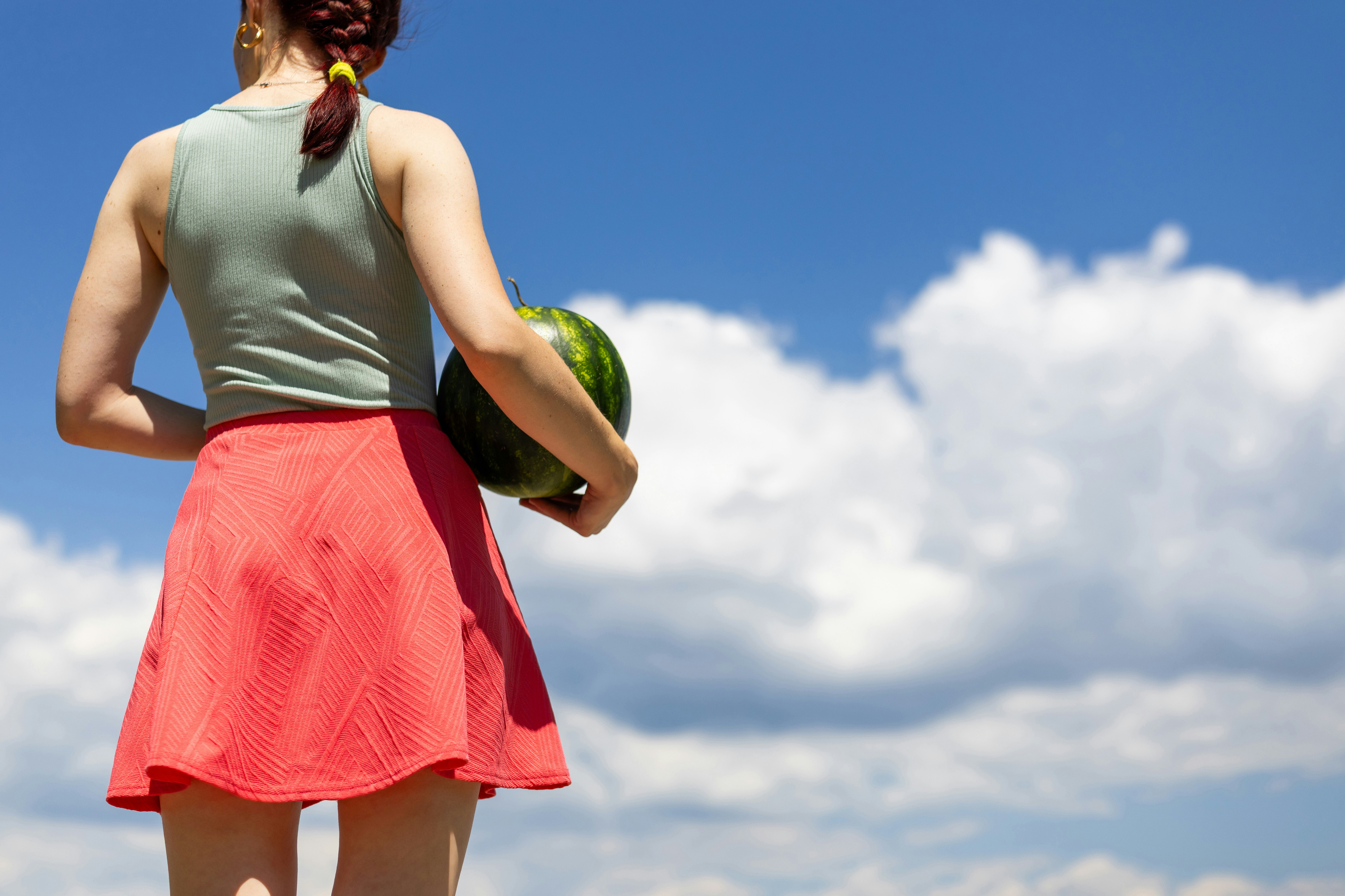 Sunlit Summer Figure: A Back View with Watermelon Acknowledges Playful Moment