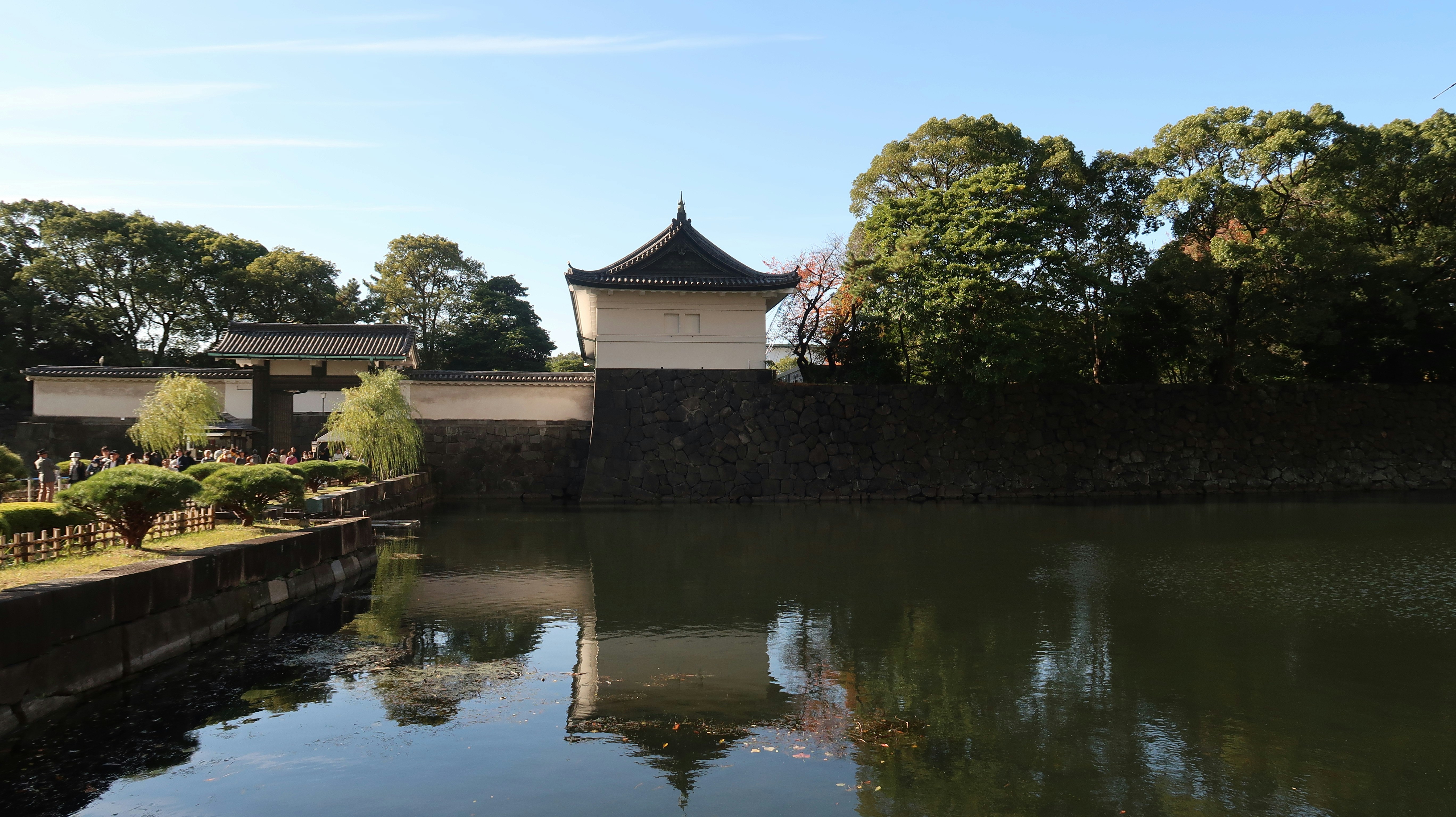 Serene moat and temple wall under a clear sky