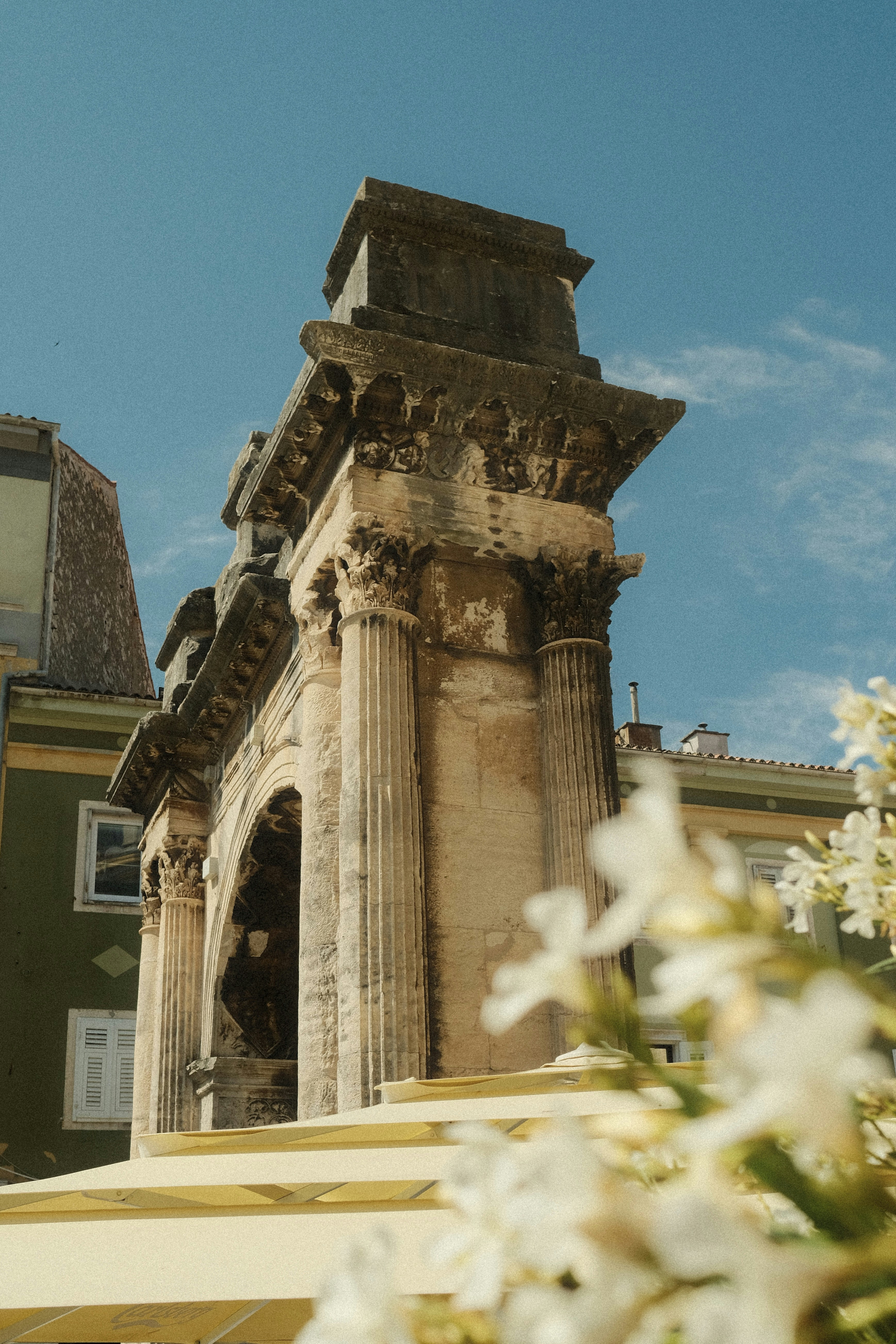 Ancient Columns Against a Bright Sky—Ruins Framing a Modern Facade