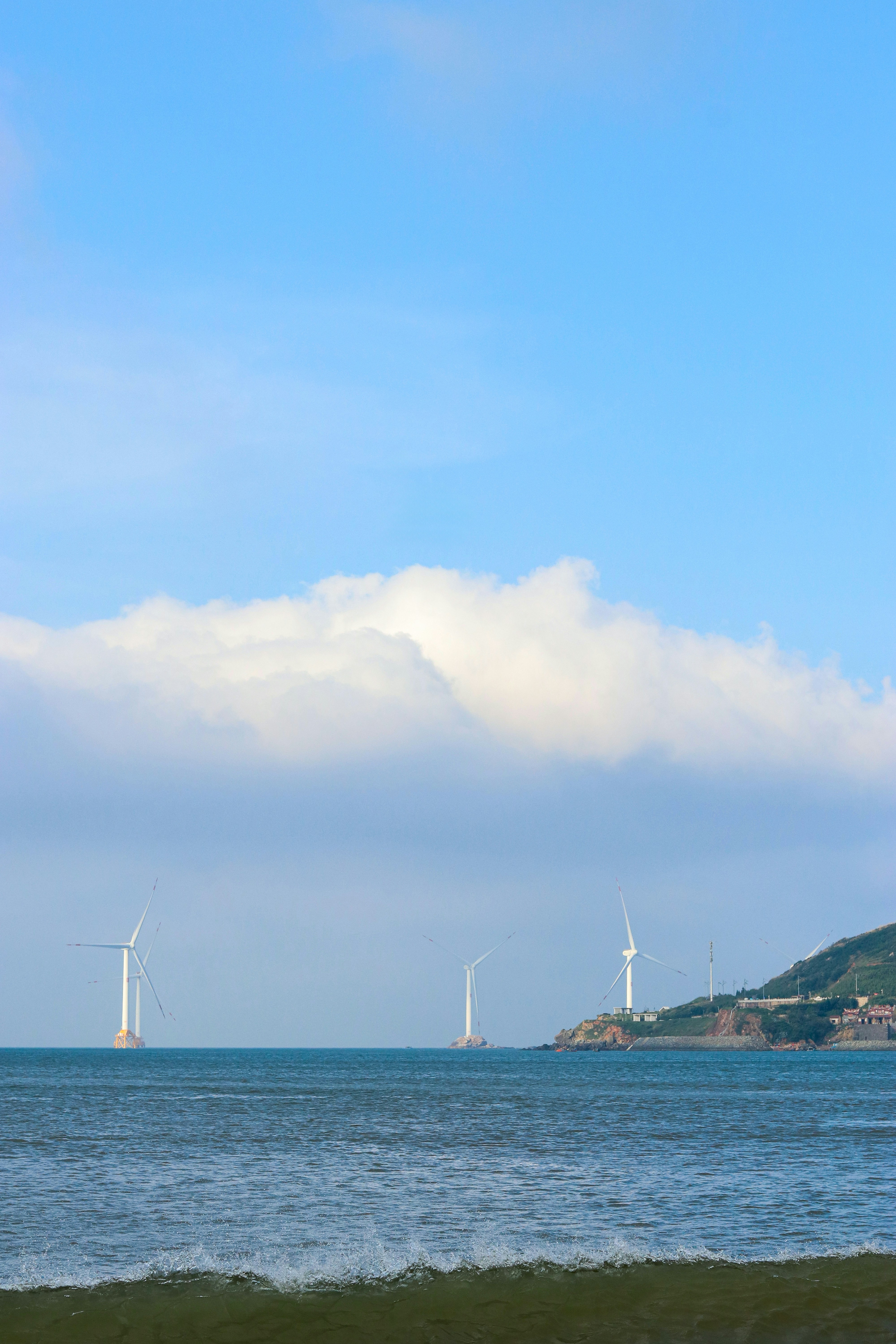 Coastal breeze and wind turbines under a calm sky