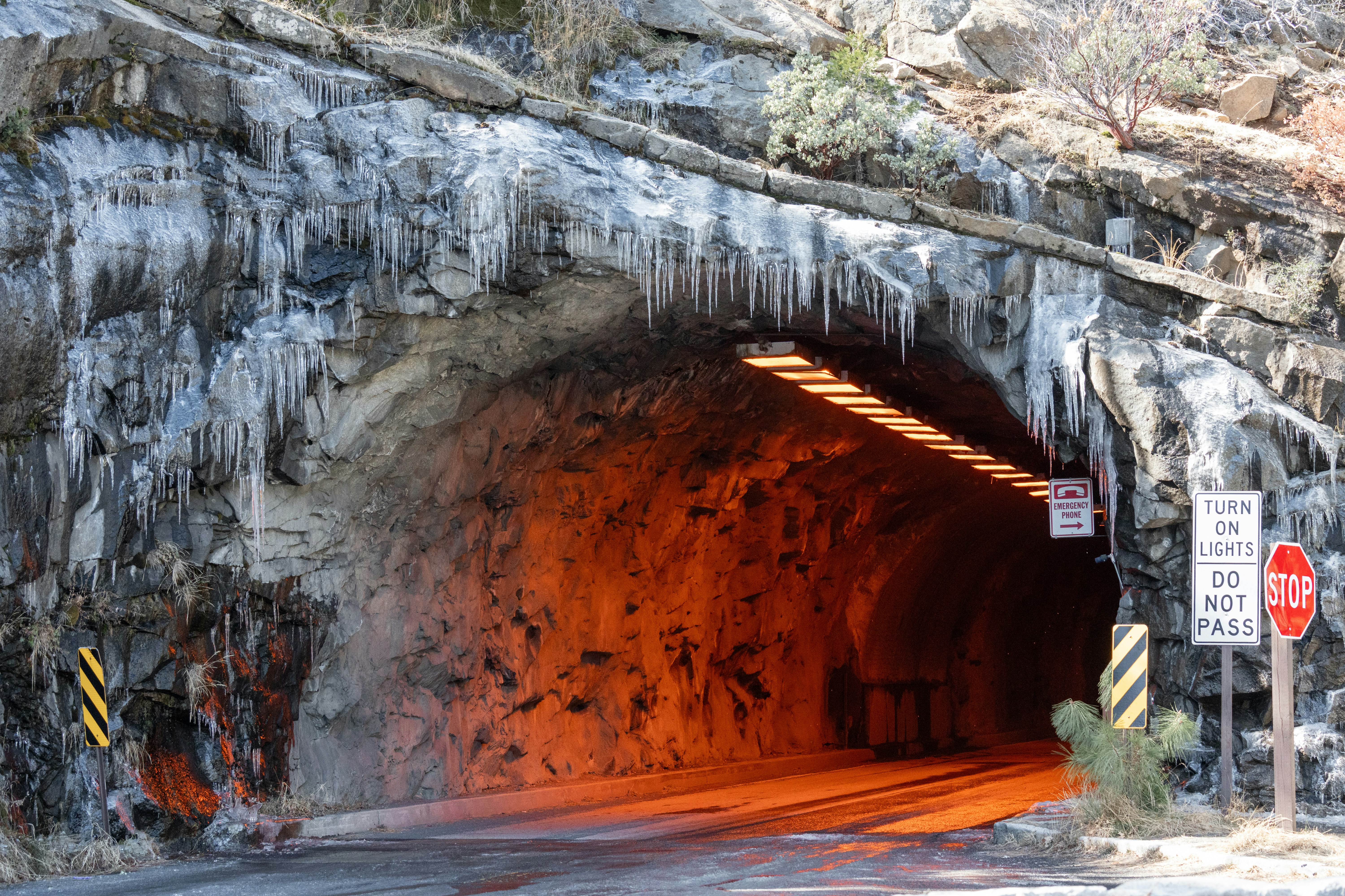 Red-Lit Tunnel Exit: Icicle-Studded Cave Reveal