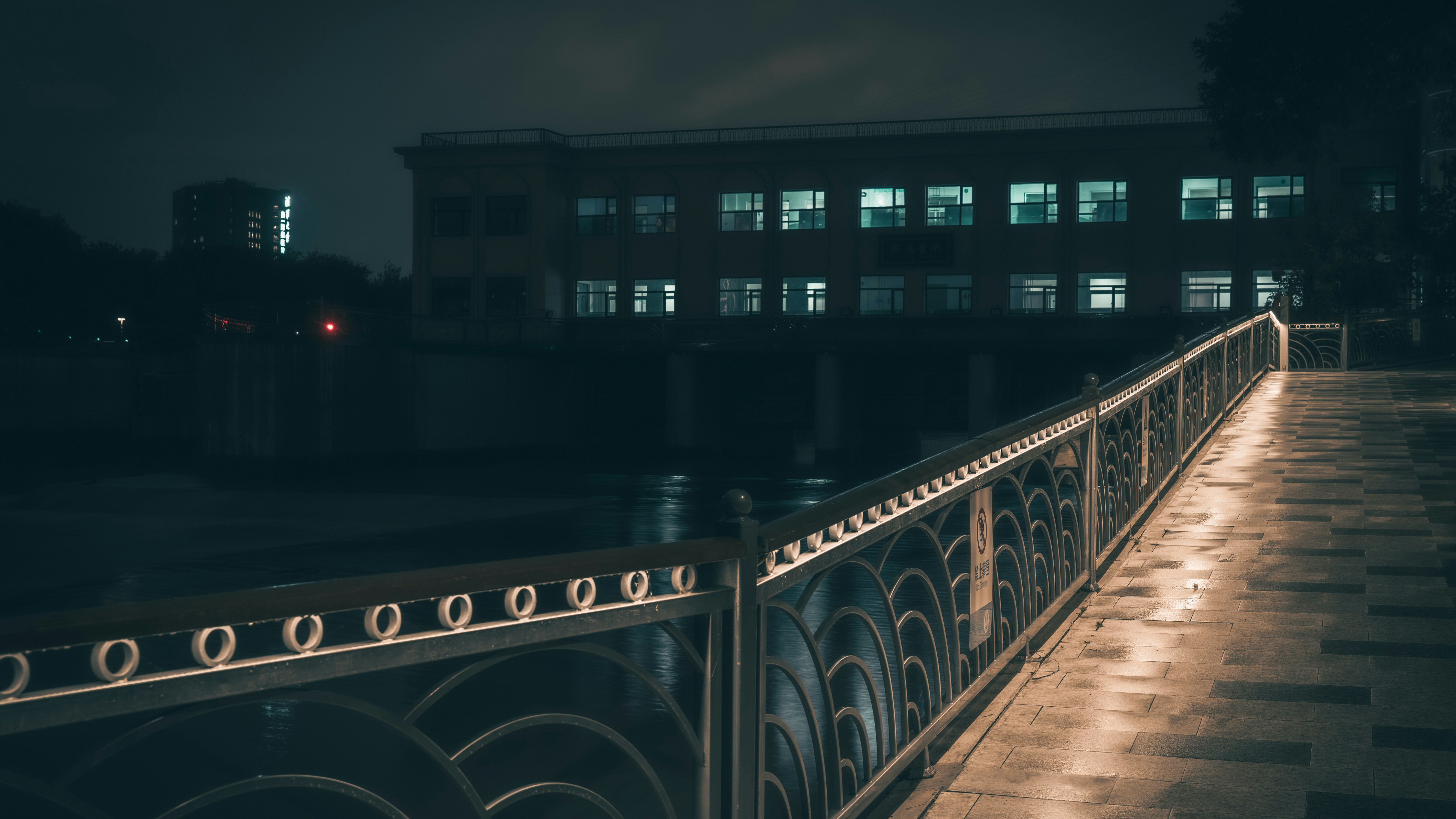 Moonlit railing leading to a quiet riverside block