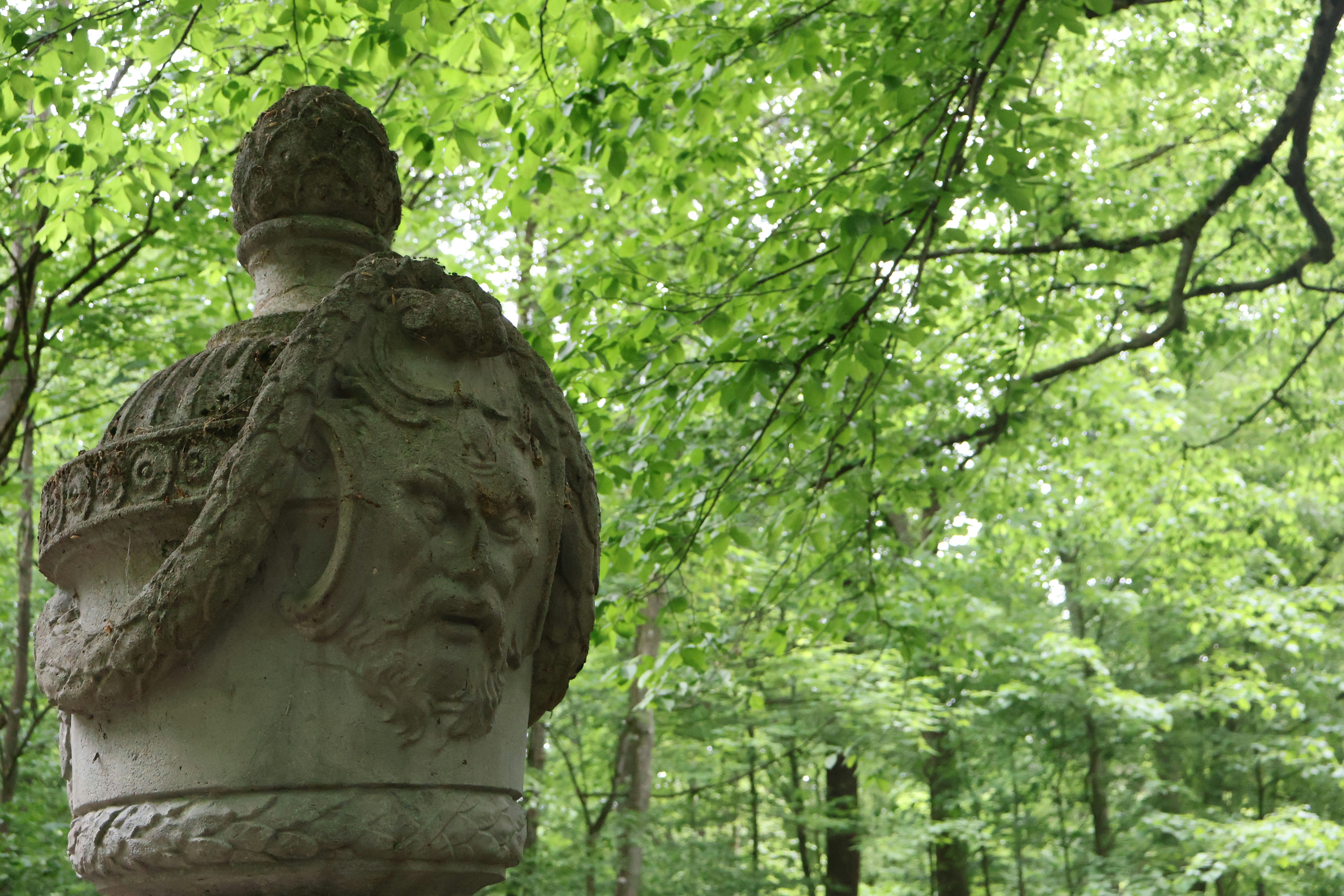 Stone Bust in a Lush Green Clearing