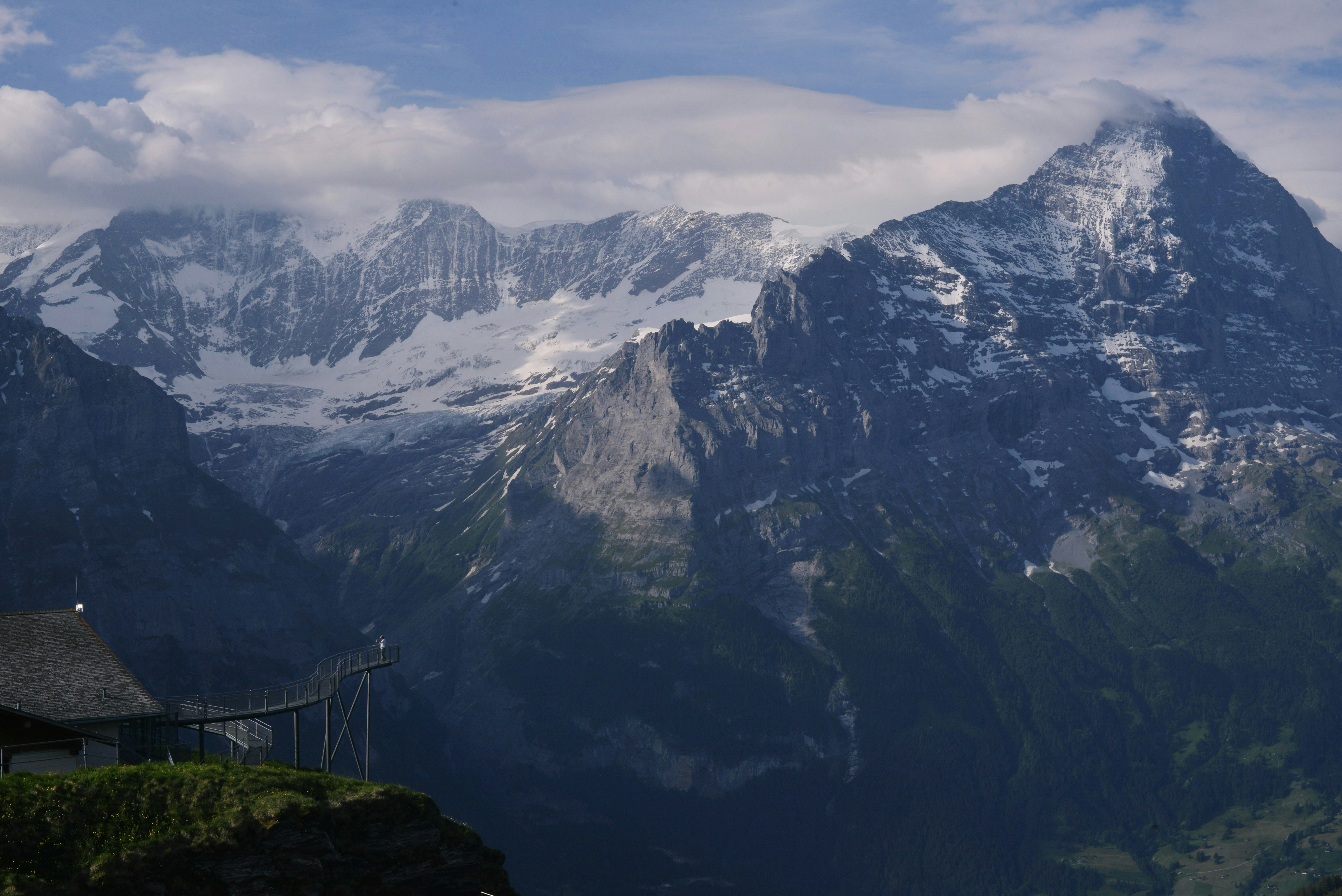 A lonely hiker standing on a viewpoint overlooking the majestic Alps