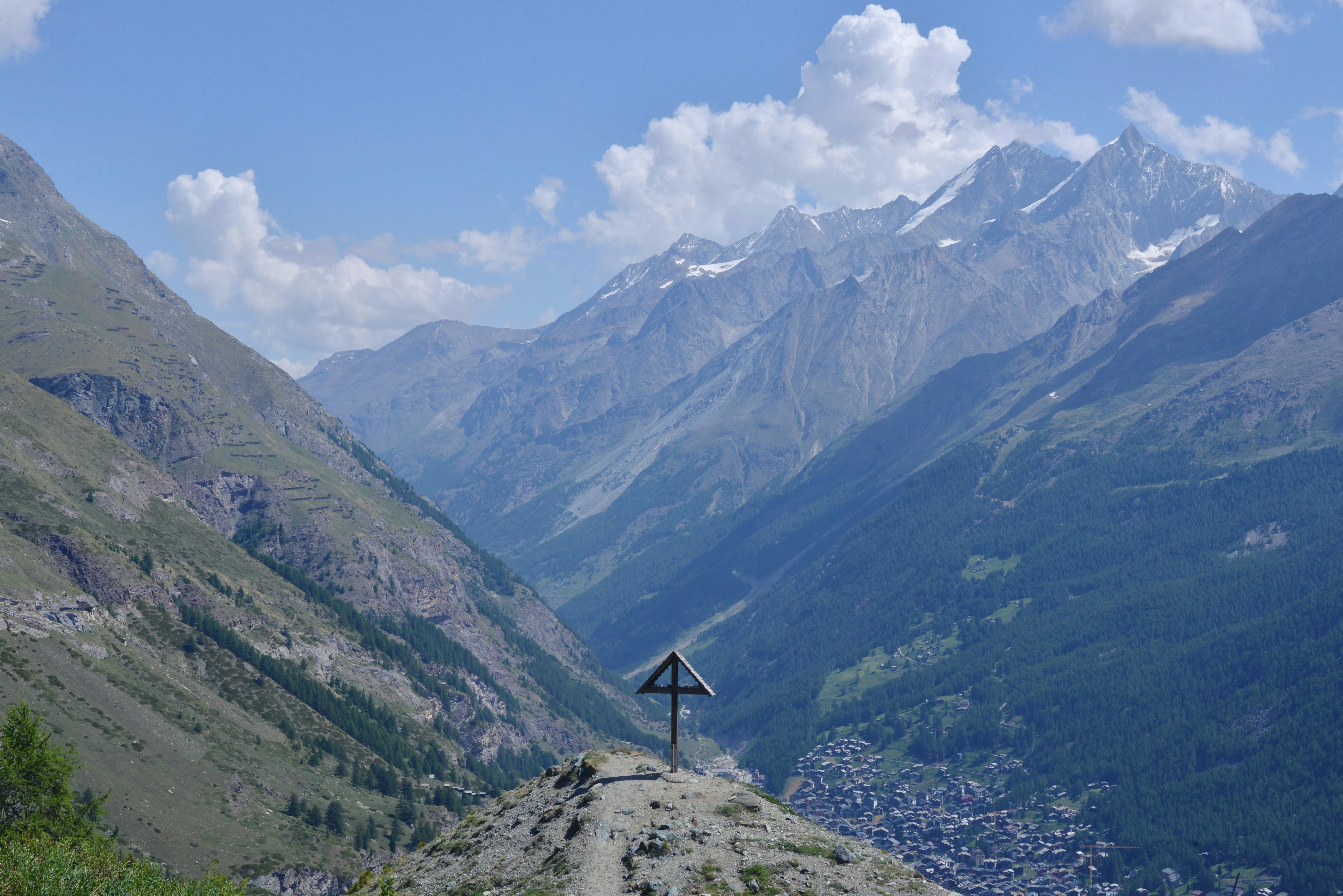 Crossing The Summit: A Lone Marker on a Mountain Ridge