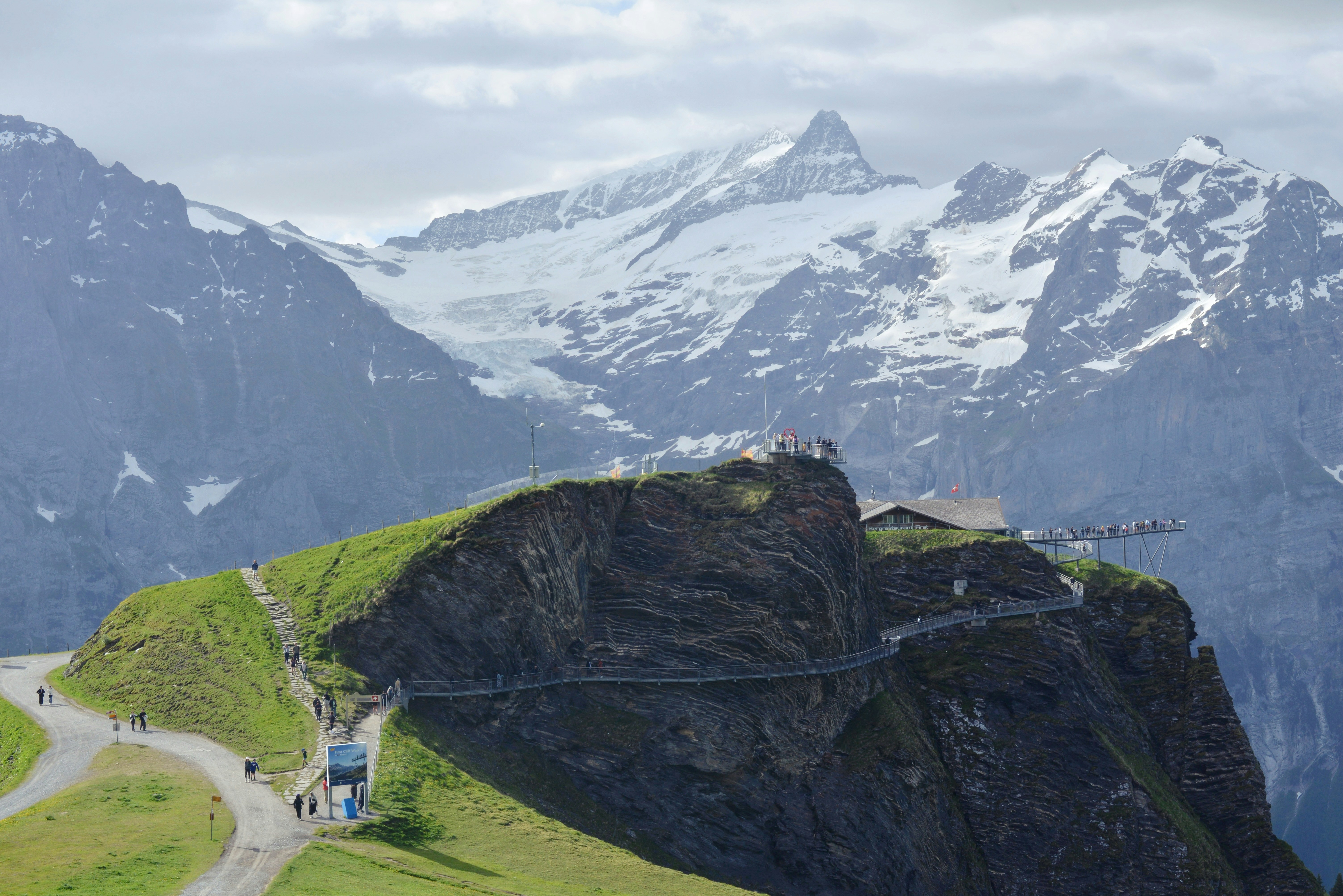 Curved Path to the Clifftop Shrine Beneath Towering Alps