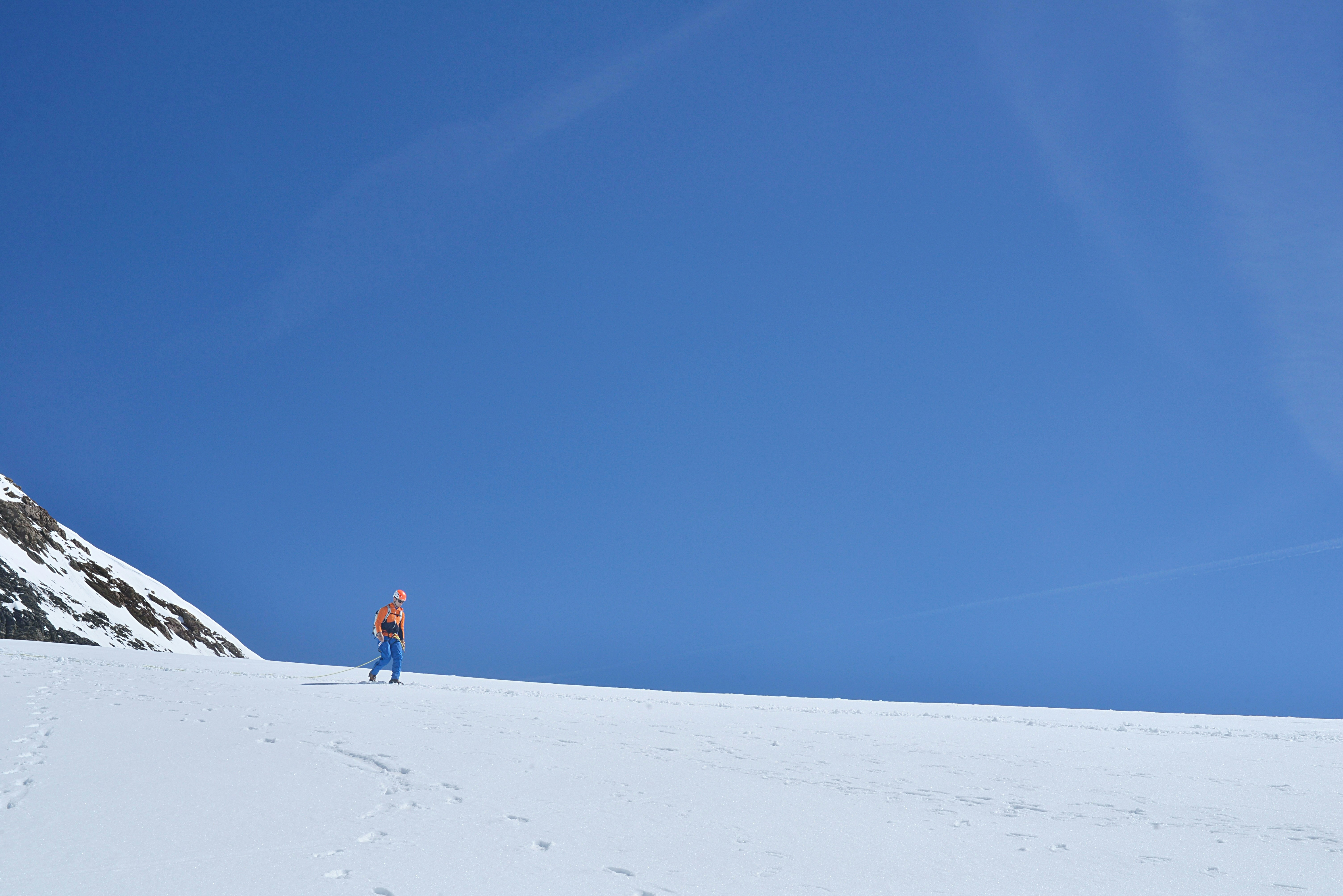 Lone Mountaineer Against a Vast Blue Backdrop