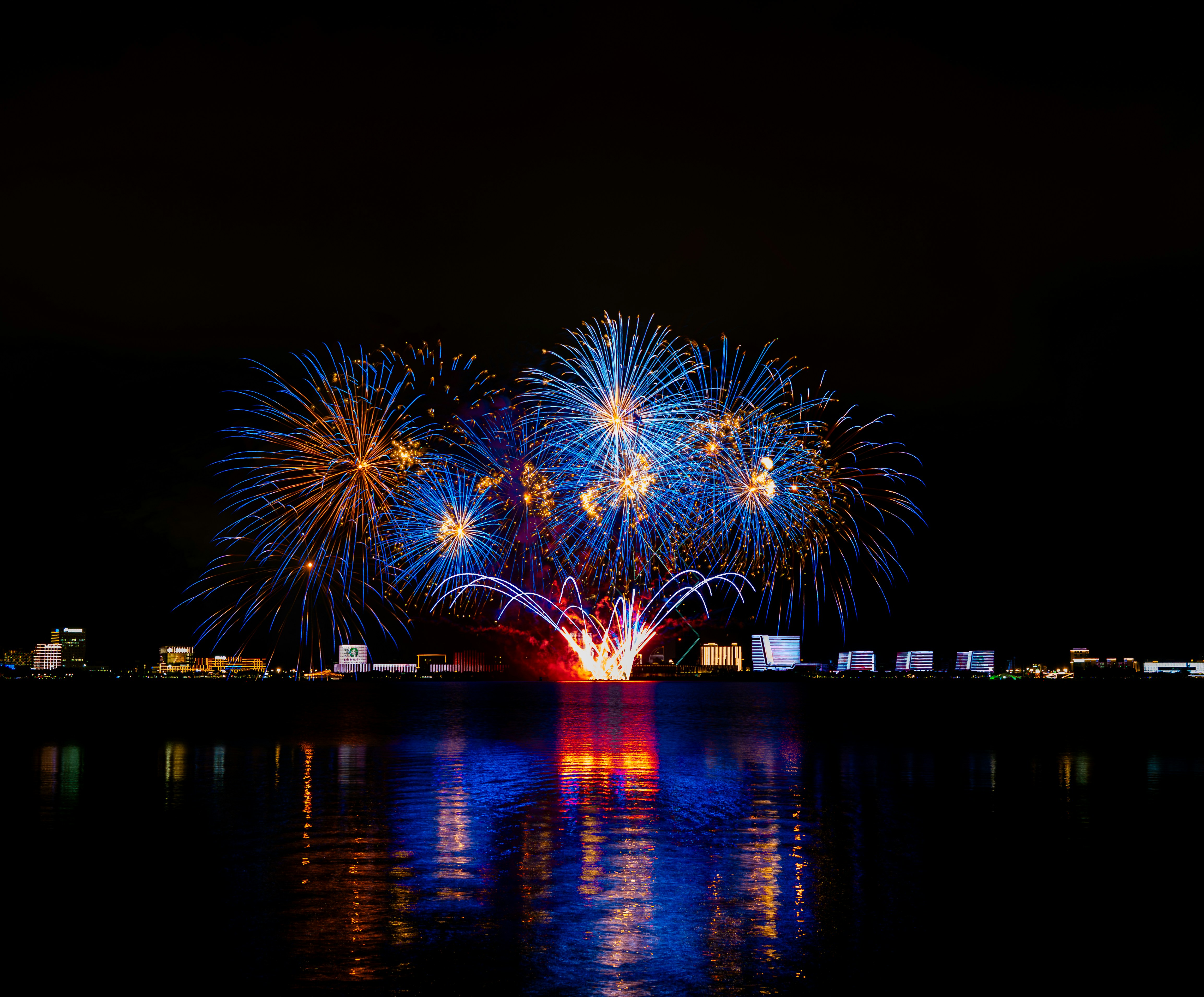 Fireworks Over Quiet Waterfront: Nightscape Reflections