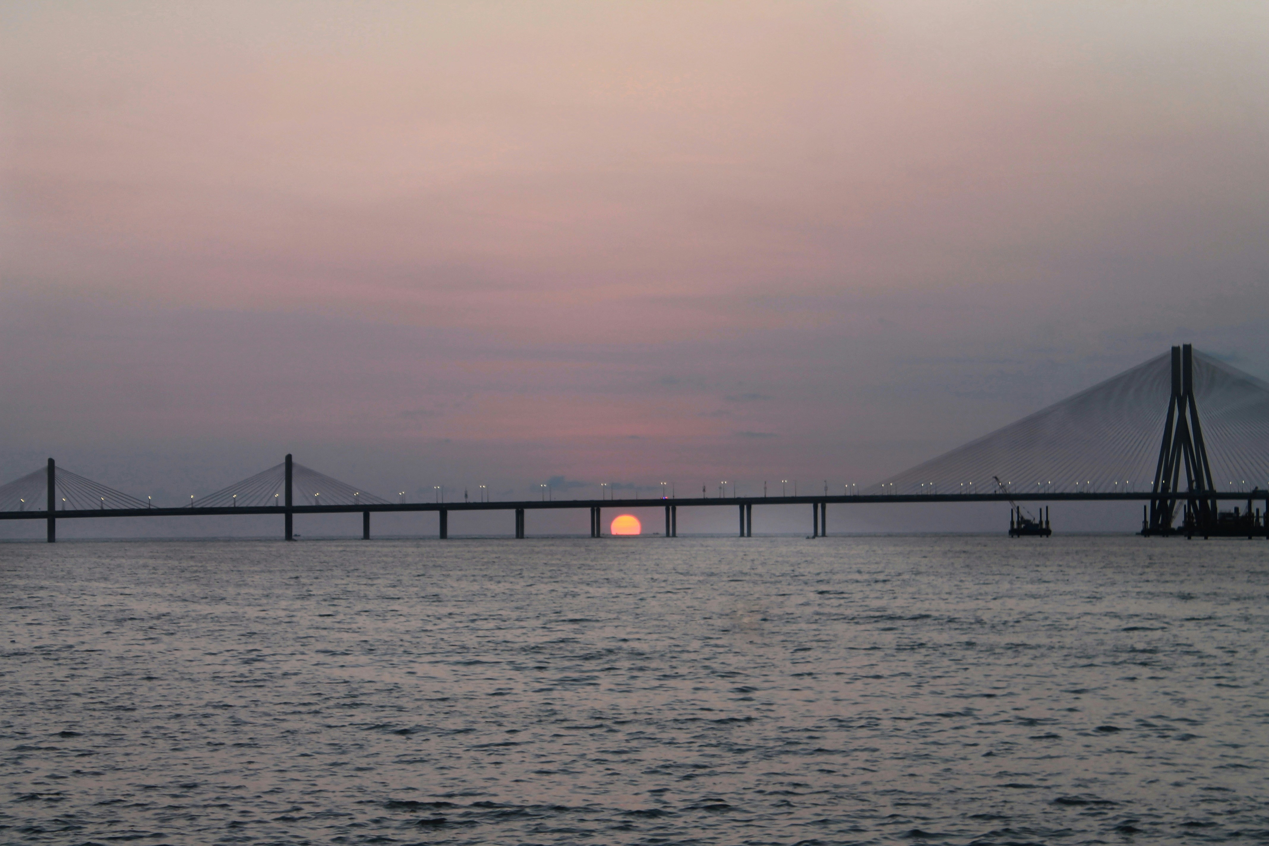 Sunset at the Serene Span: A Coastal Bridge Descends Into Dusk