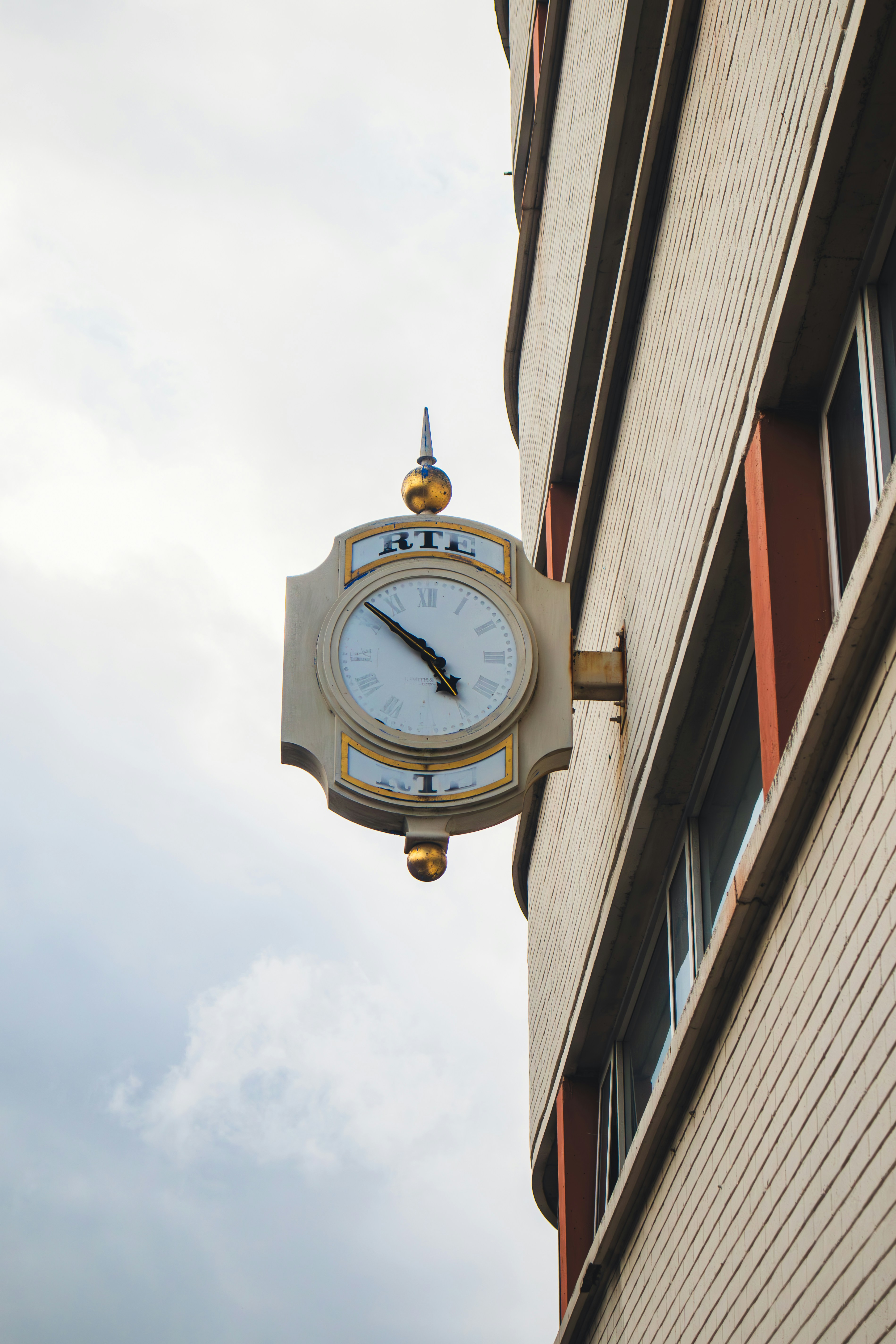 Clock Tower on the Brick Facade: A Timepiece Adrift by the Street