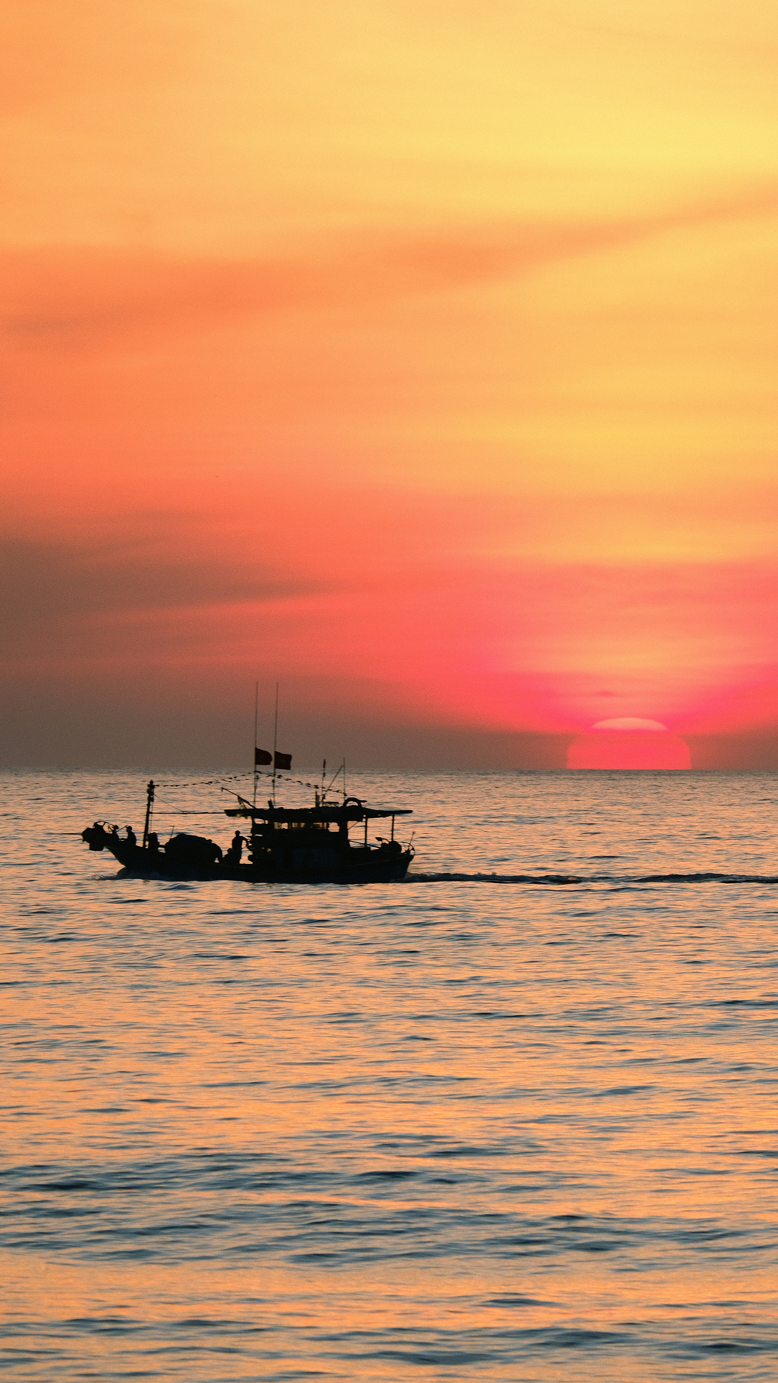 Silhouette at Sunset: A Fishing Boat on Quiet Waters