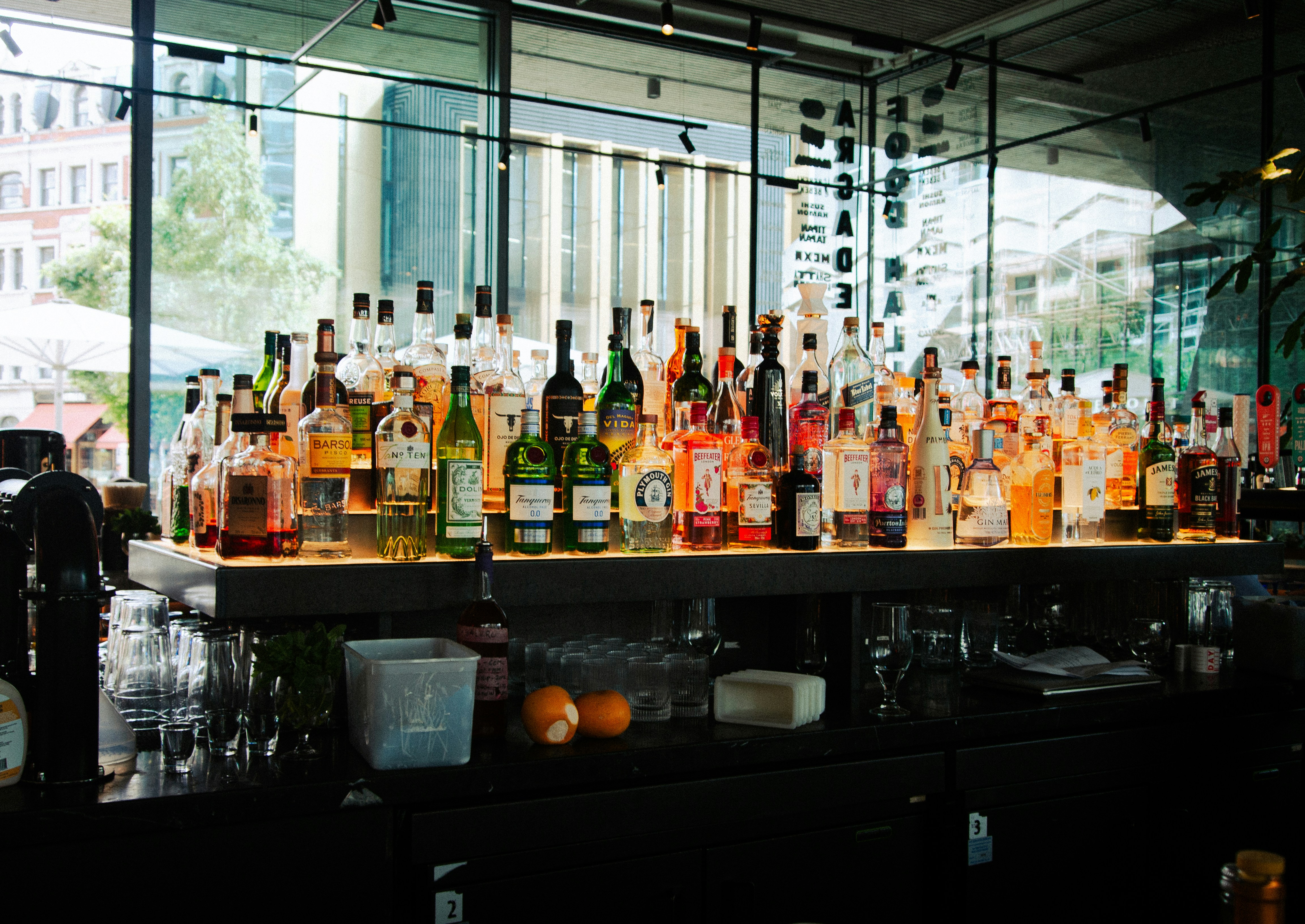 Liquid Spectrum: Bottles Align at a City-Bar Sunset
