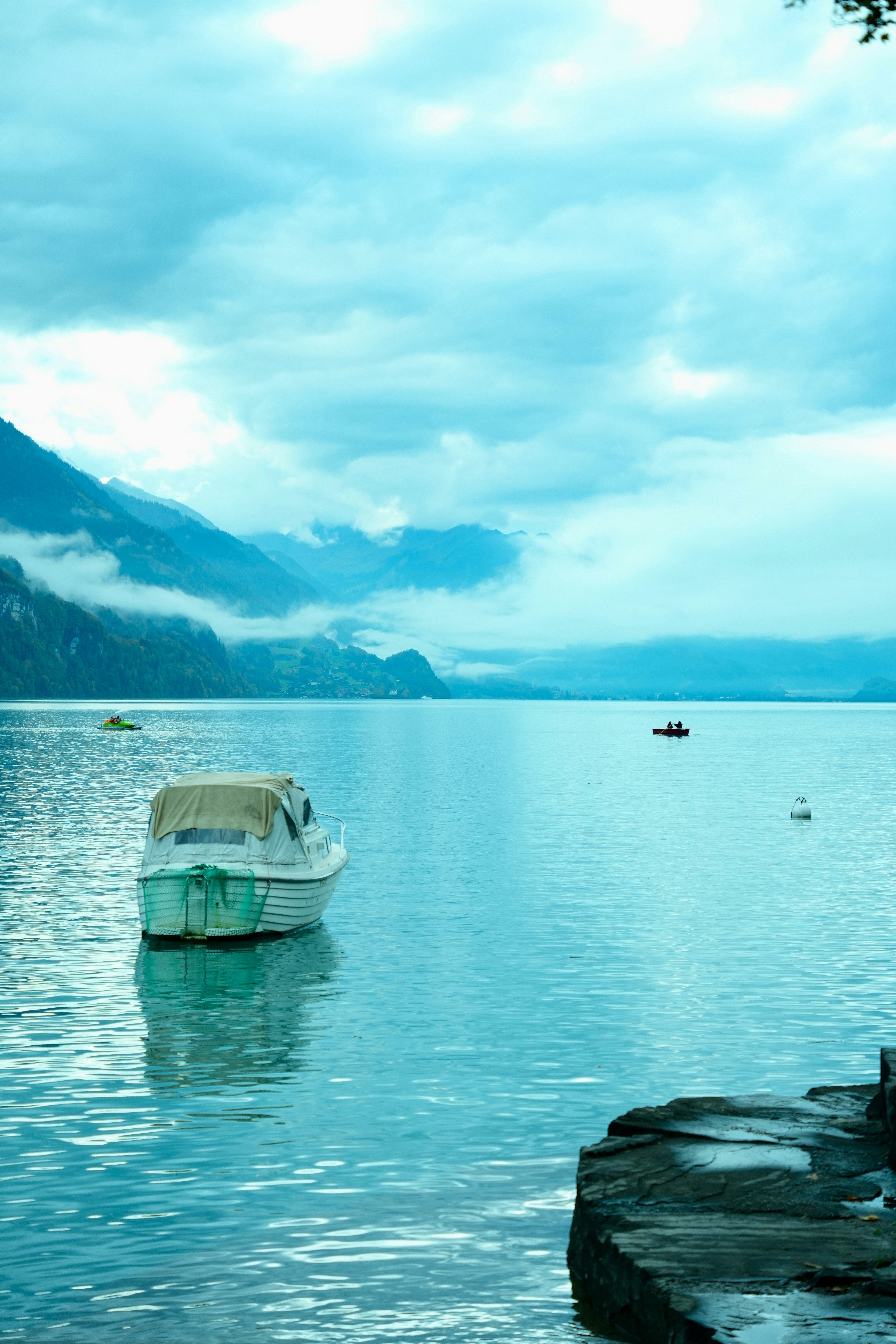 Misty Lakefront with a moored boat under a blue-tinged sky