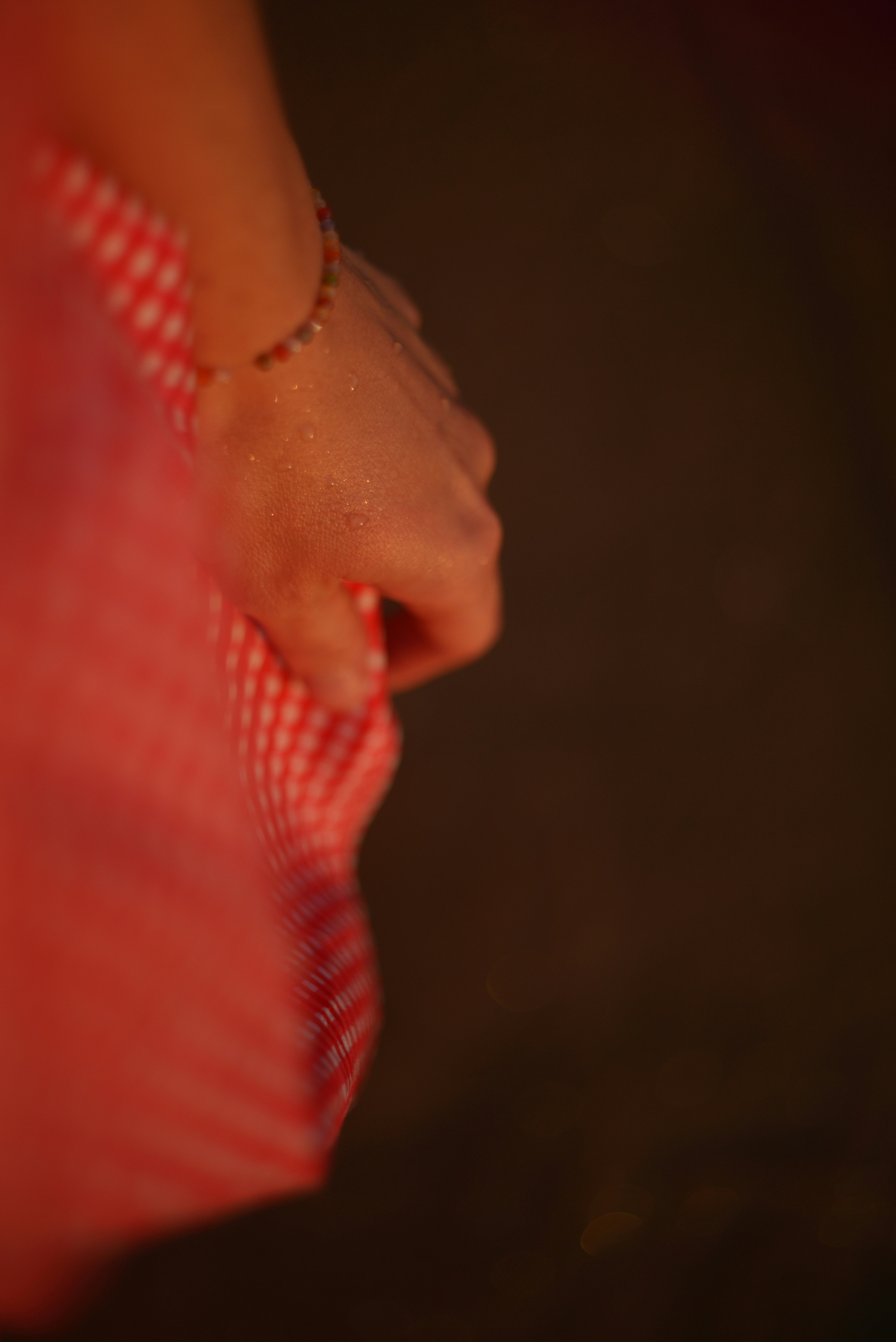 Flicker of Red Fabric: A Quiet Hand in Dim Light