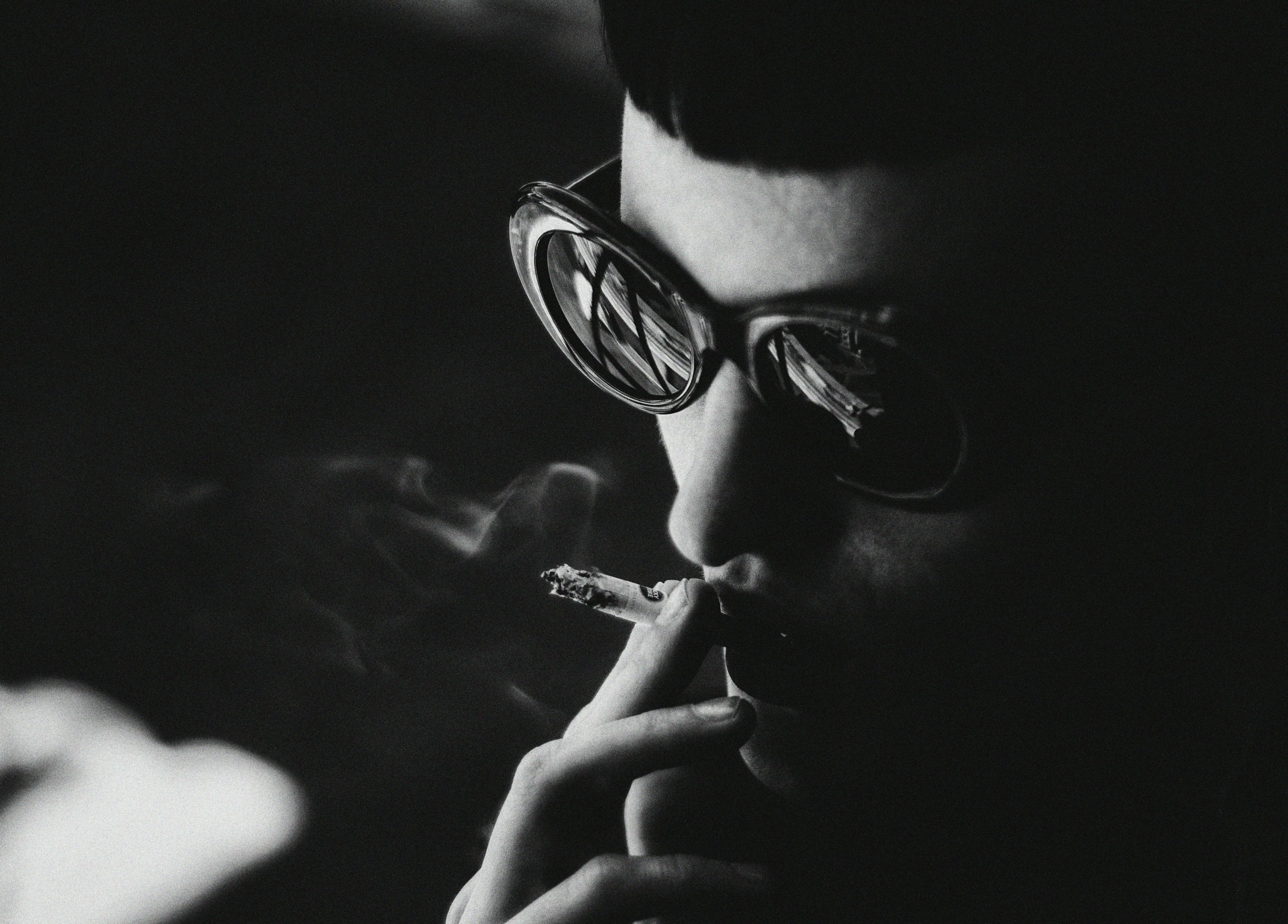 Shadowed Intimacy: A Cigarette, Glasses, and Quiet Focus