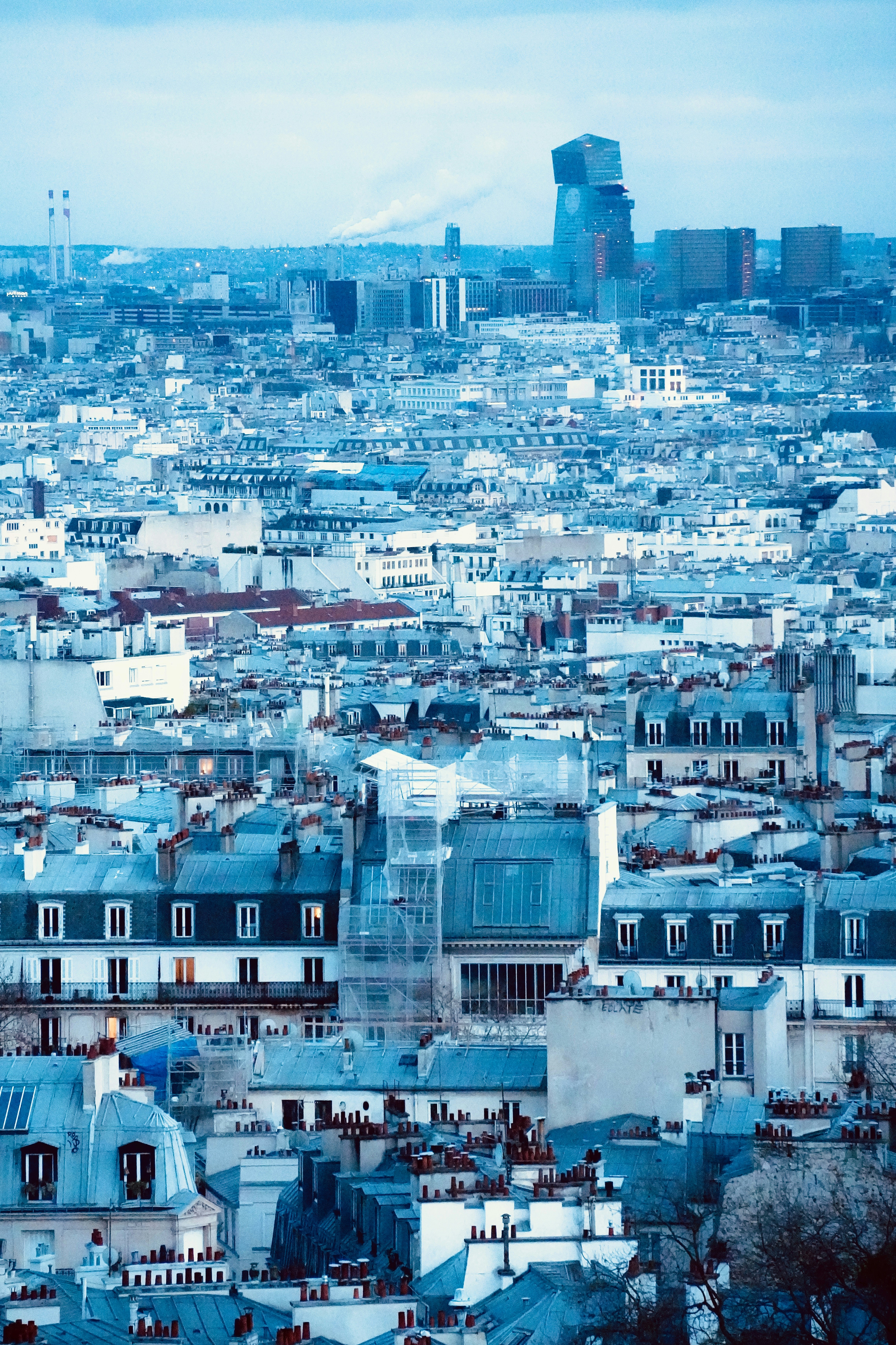 City of Blue Silhouettes: Rooftops Stretch Toward a Smoky Skyline