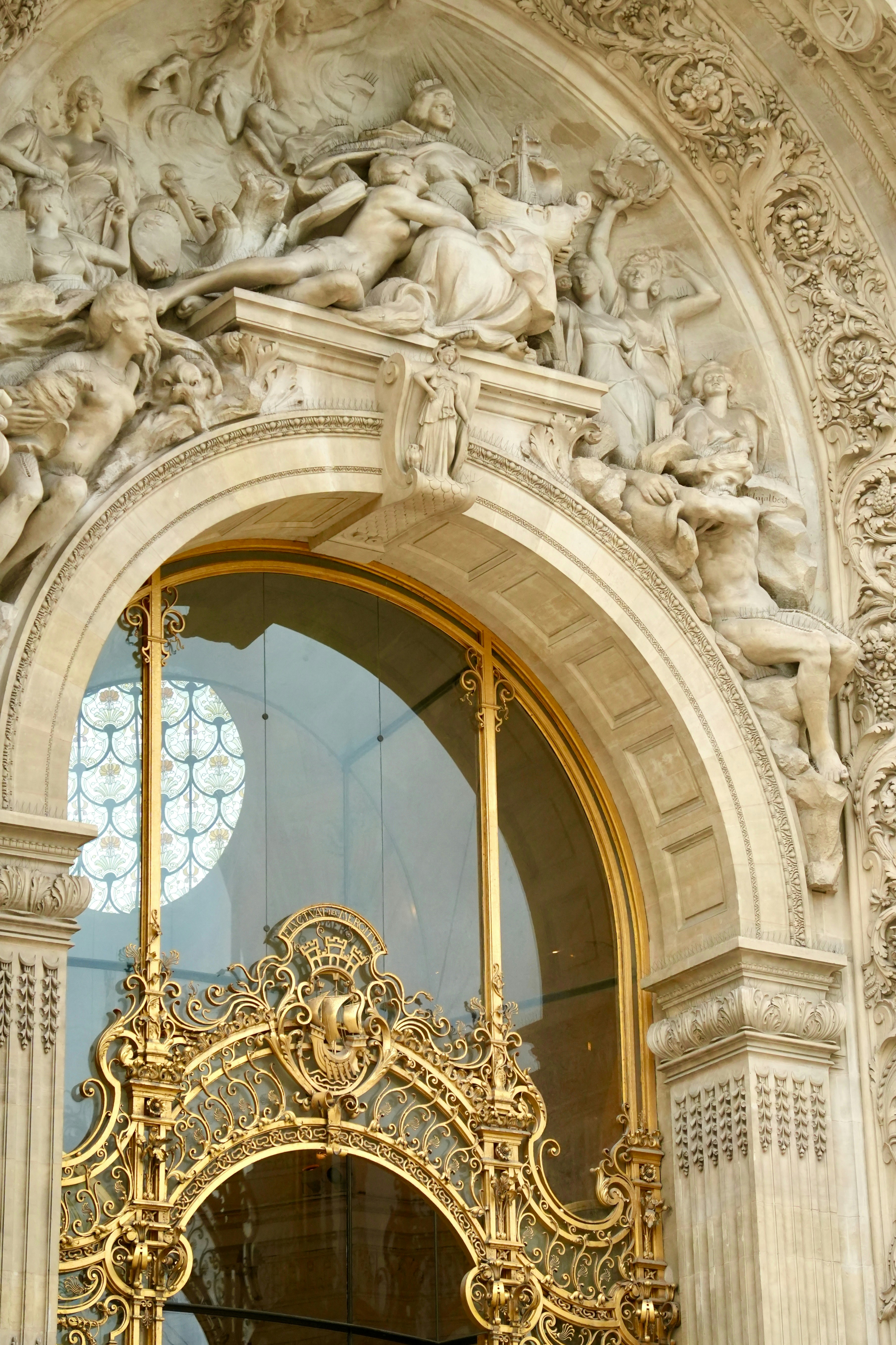 Ornate arch and sculpted facade framing a gilded gate