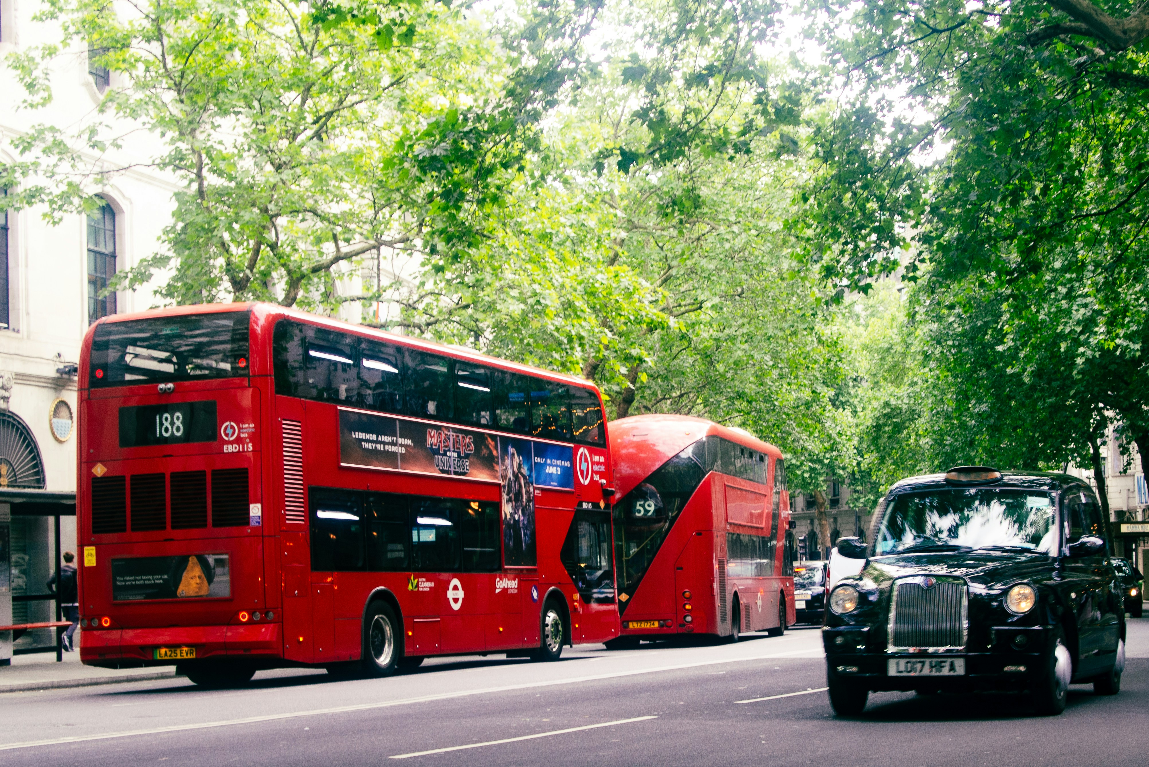 London Streets in Motion: Red Buses and a Classic Taxi