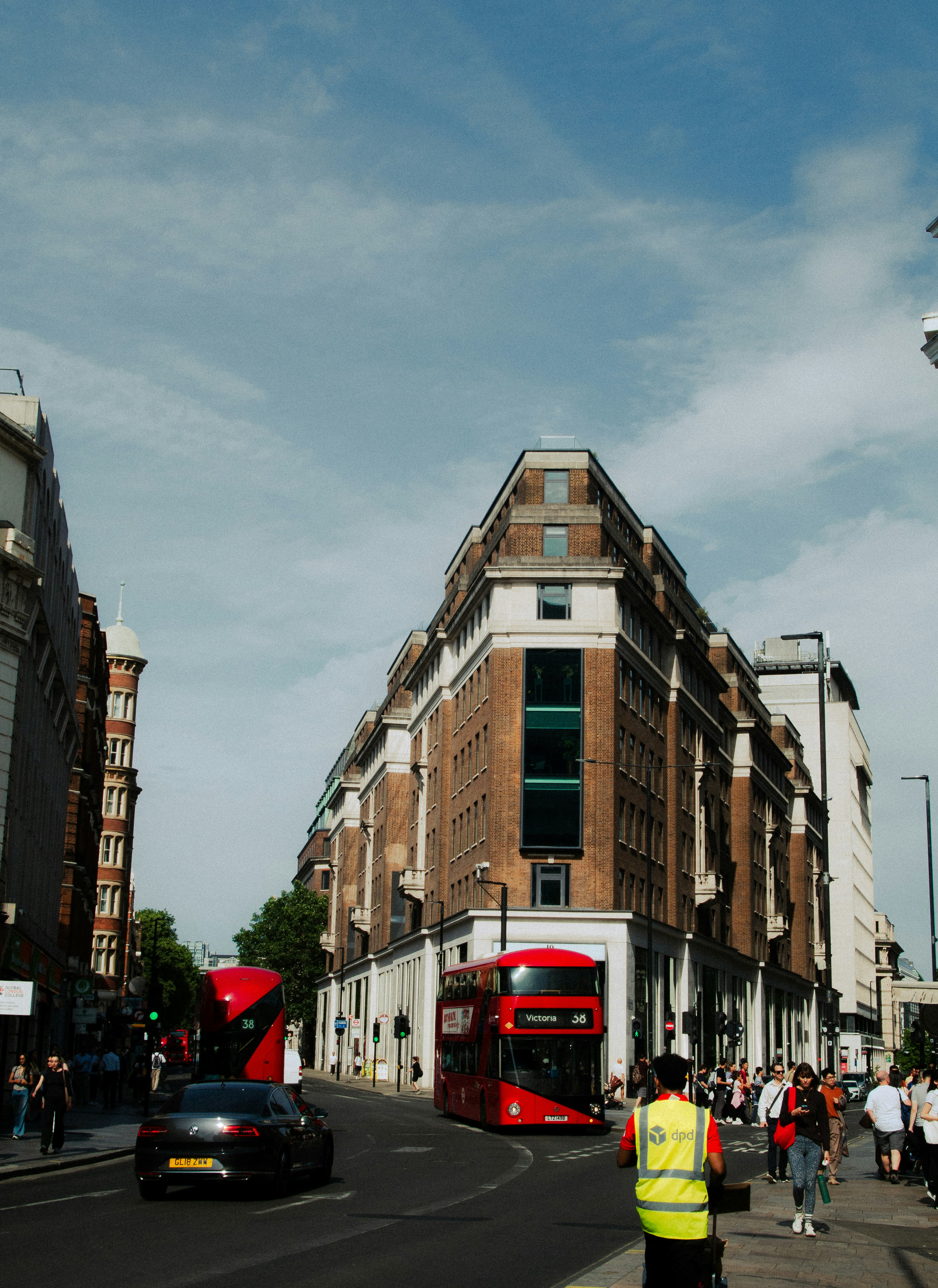 London Street Symphony: Red Buses and Brick Facades Under a Blue Sky