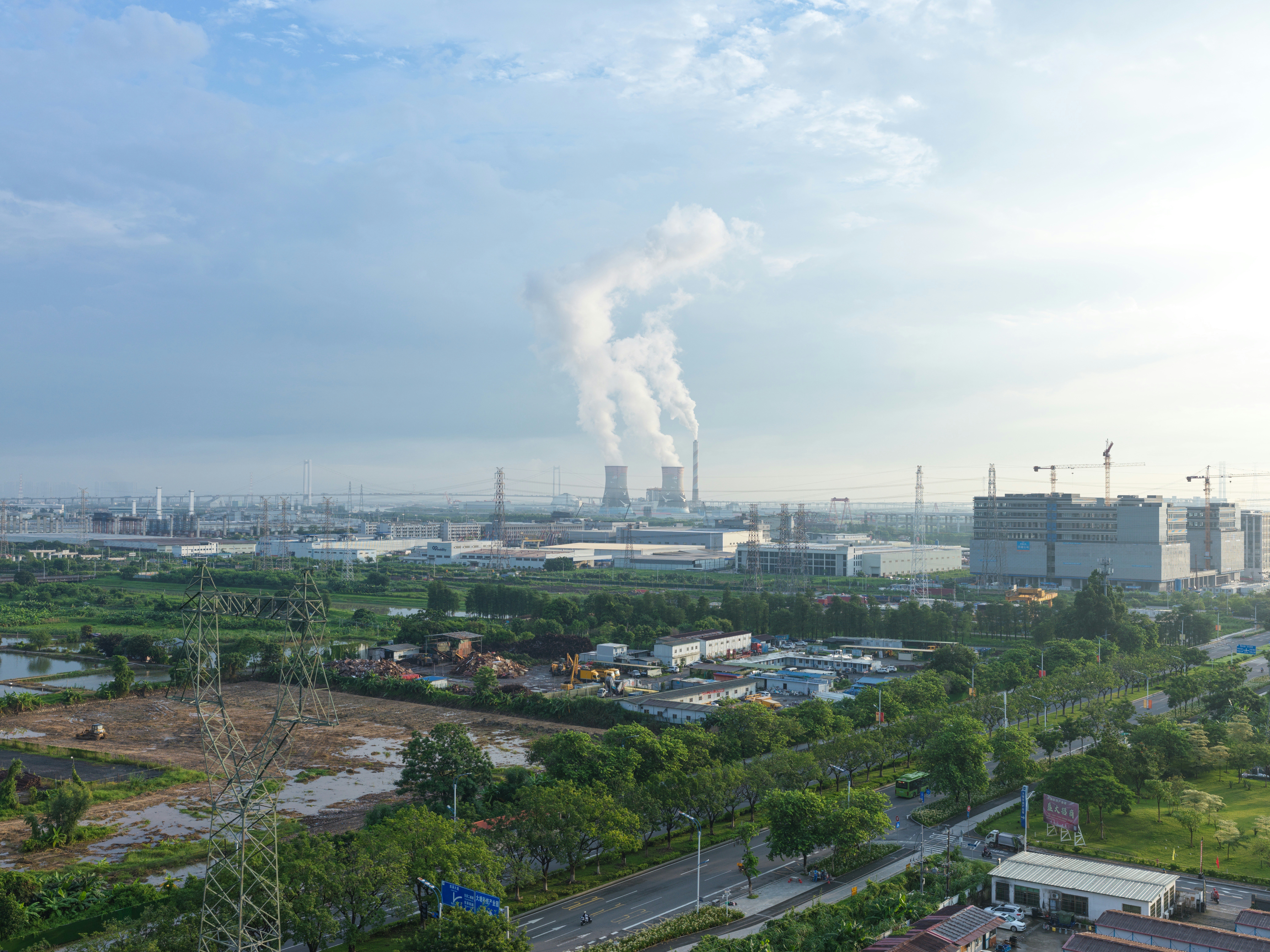 Industrial horizons: smoke stacks and cranes over a developing city