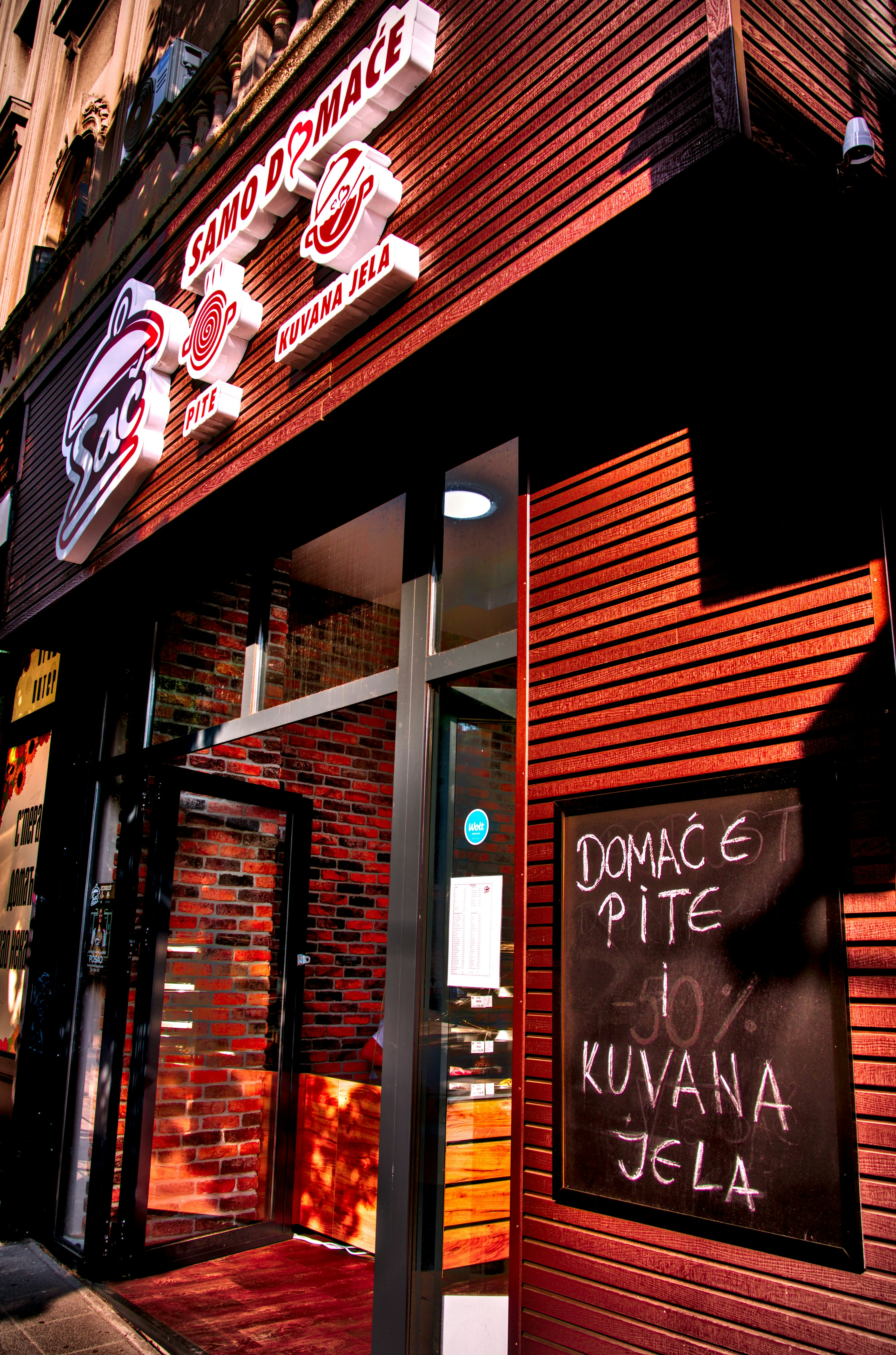 Brick-faced storefront and chalkboard sign bathed in afternoon light