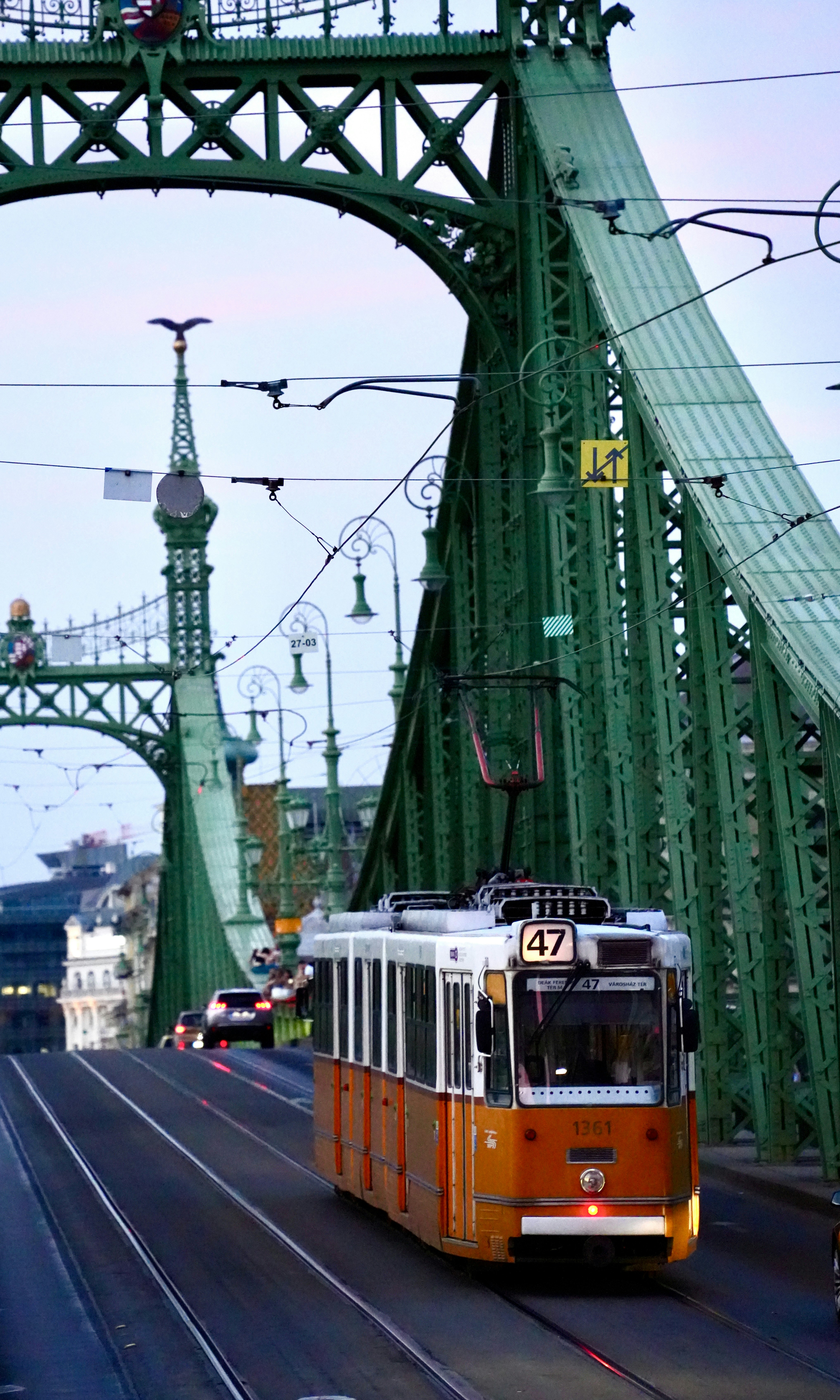 Orange Tram Crossing the Green Arch: A City Wake-Up on the Bridge