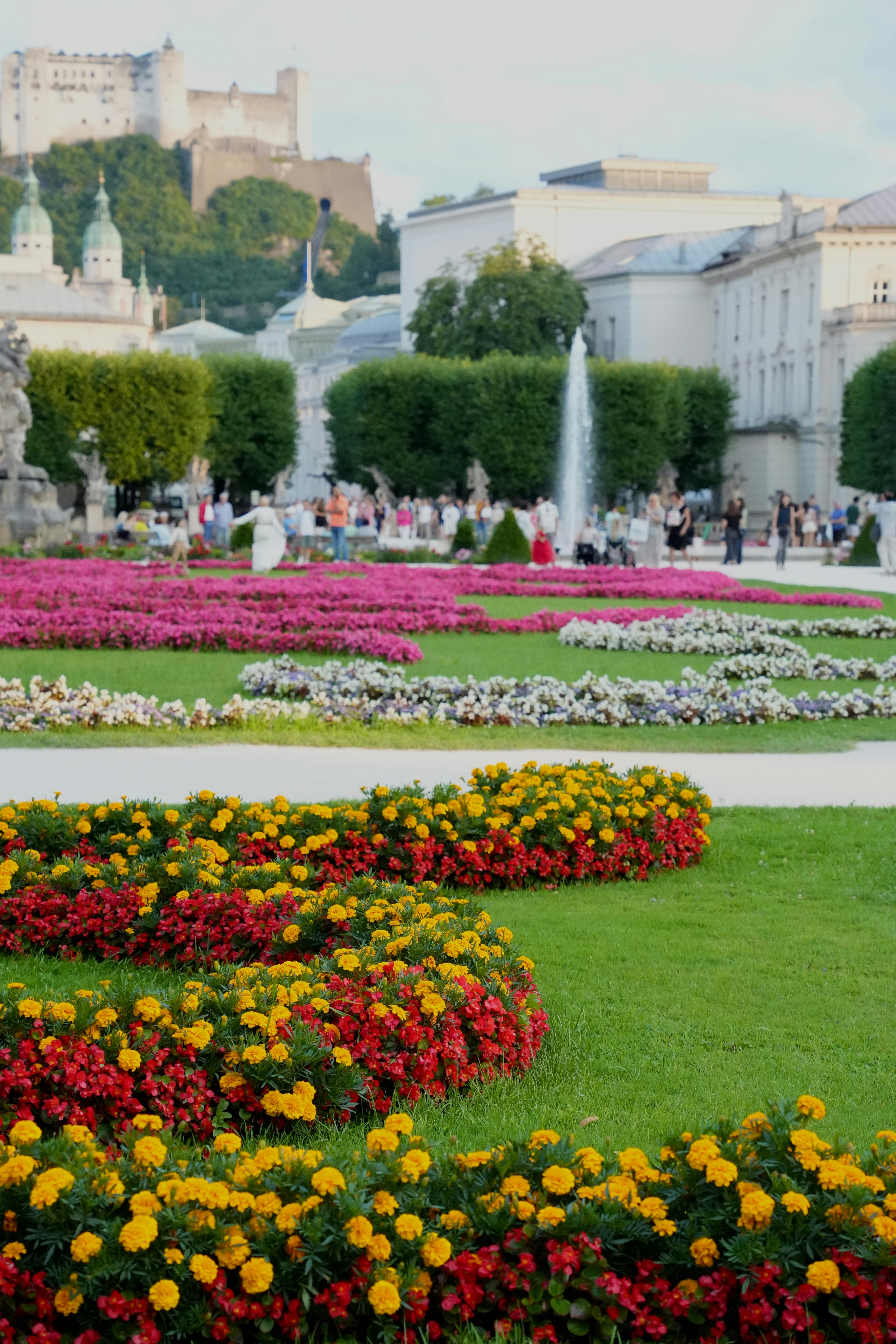 Vivid Versailles flower beds leading to a historic plaza