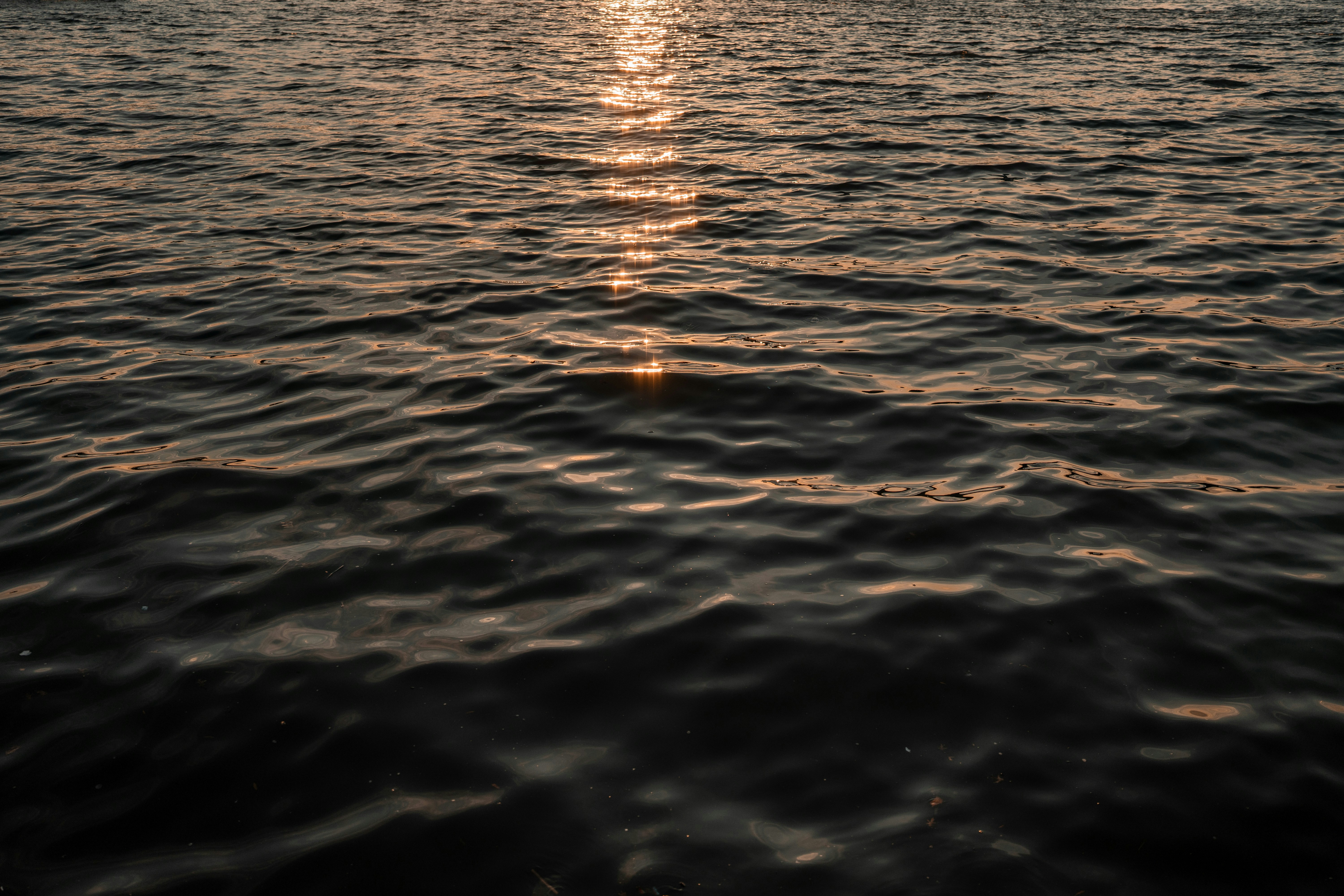 Glimmer on Quiet Waves: Sunset Reflections Across Dusk Seas