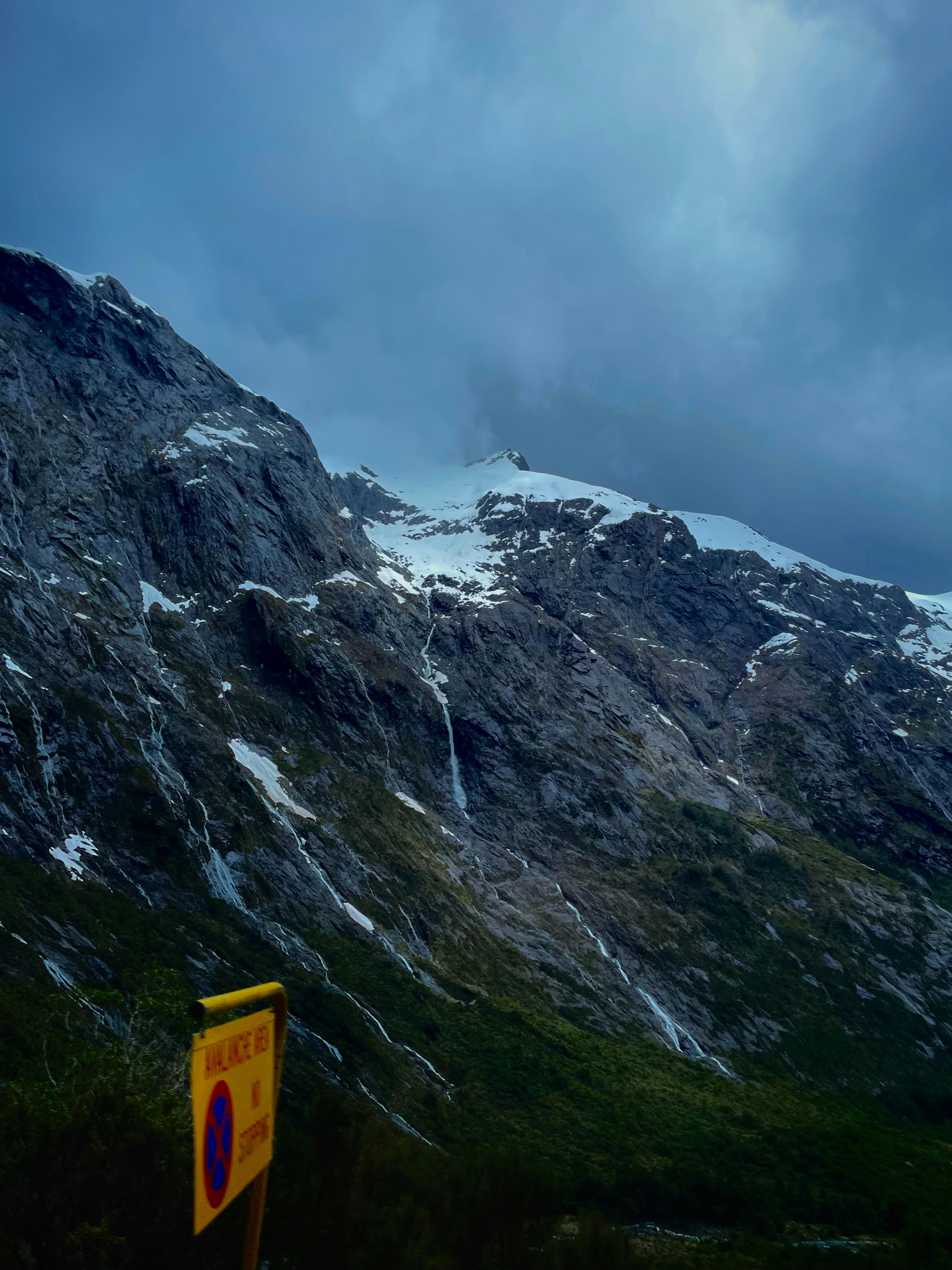 Snow‑kissed cliff edge under brooding skies