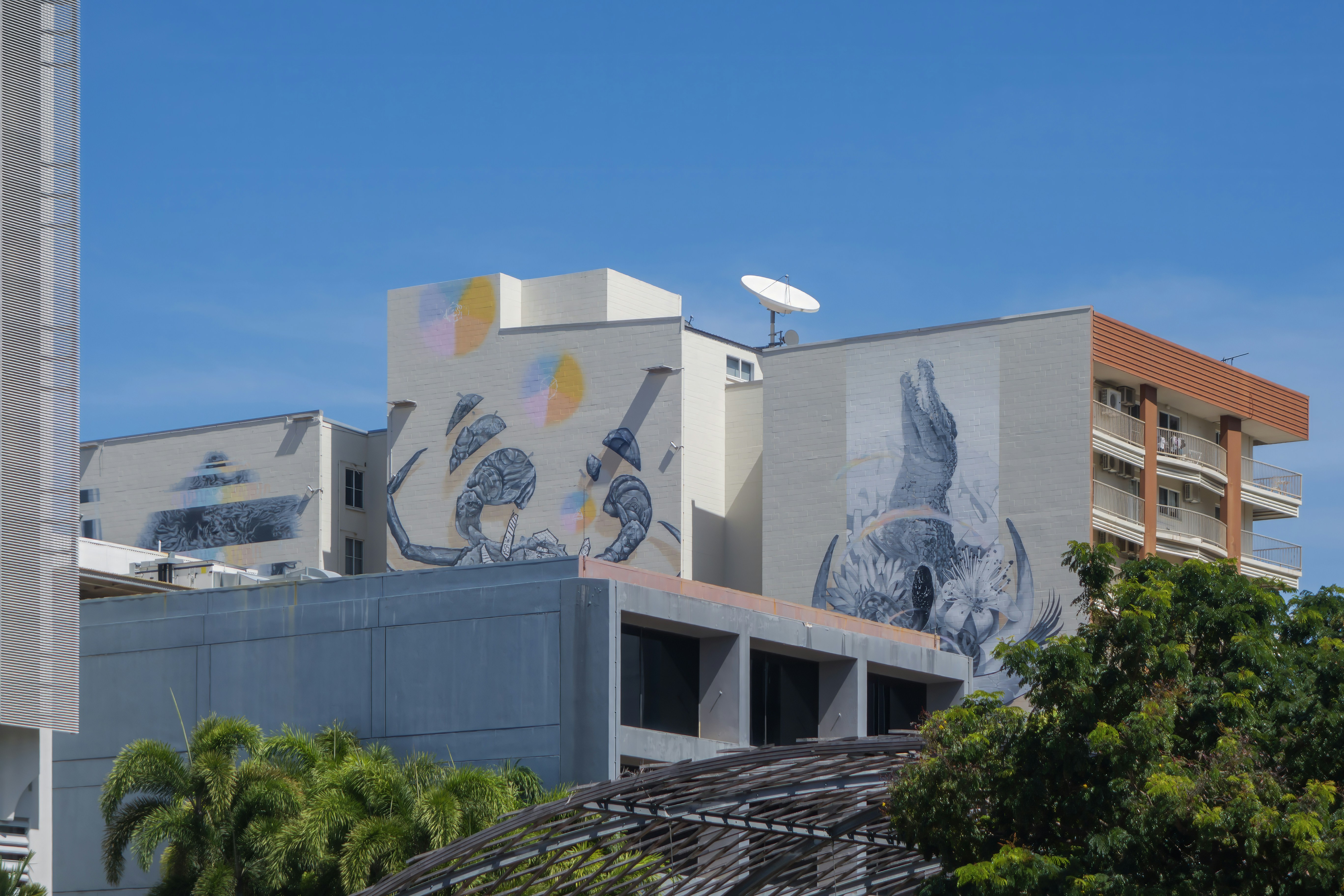 Muraled Facade: Colorful Scenes on Urban White