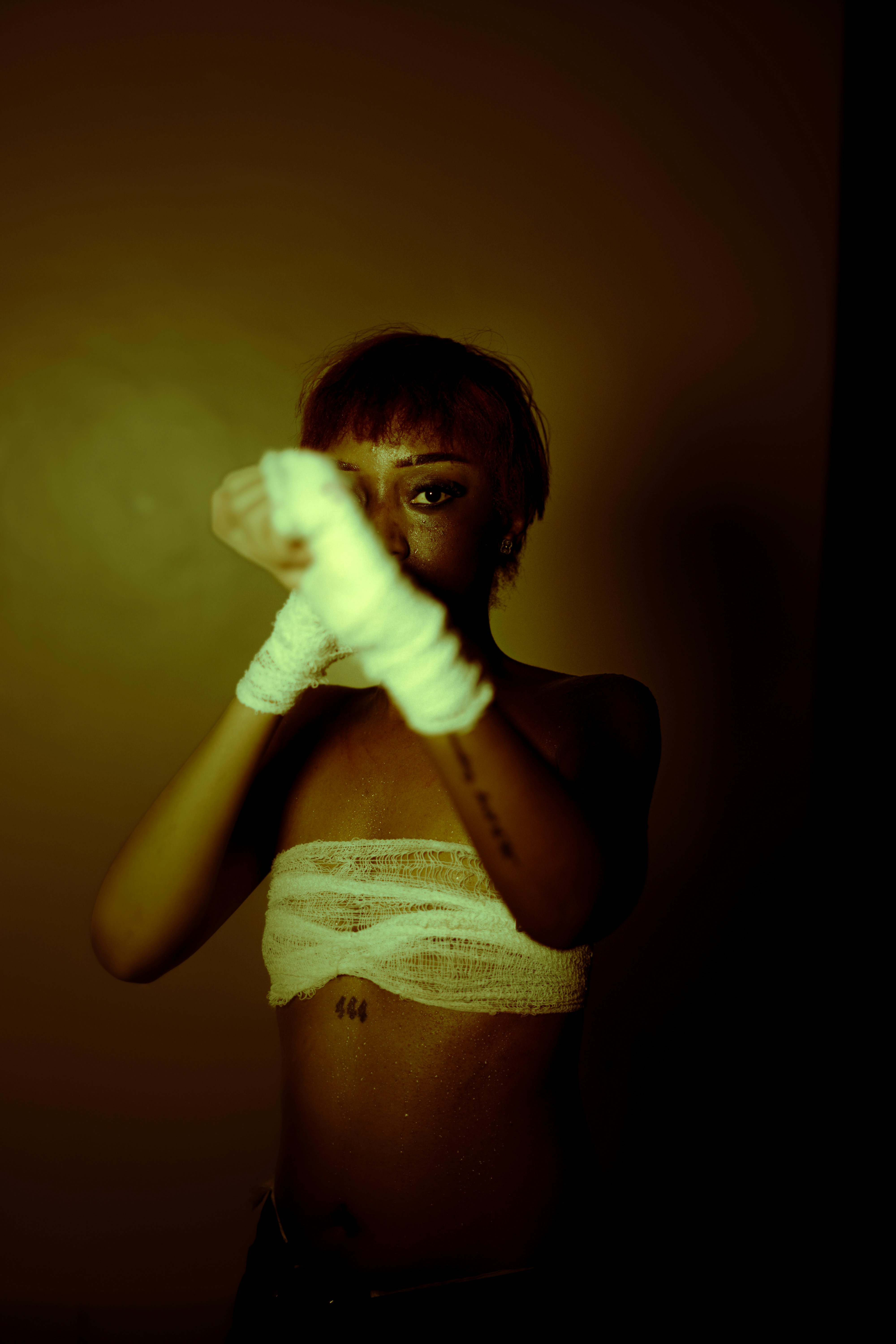 Wrapped Silence: A Fist of Light in a Shadowed Studio