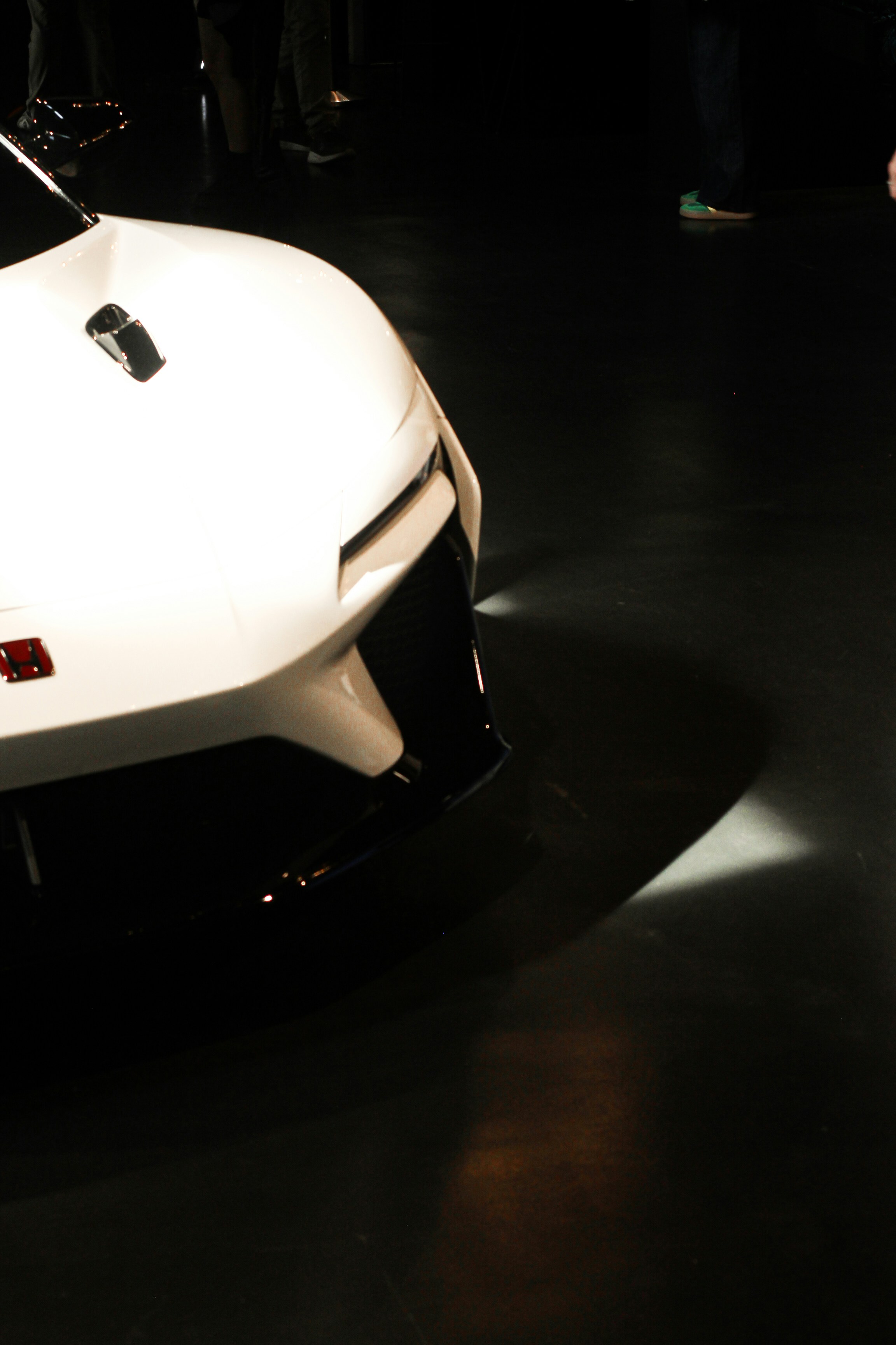 White sports car at a dim showroom edge
