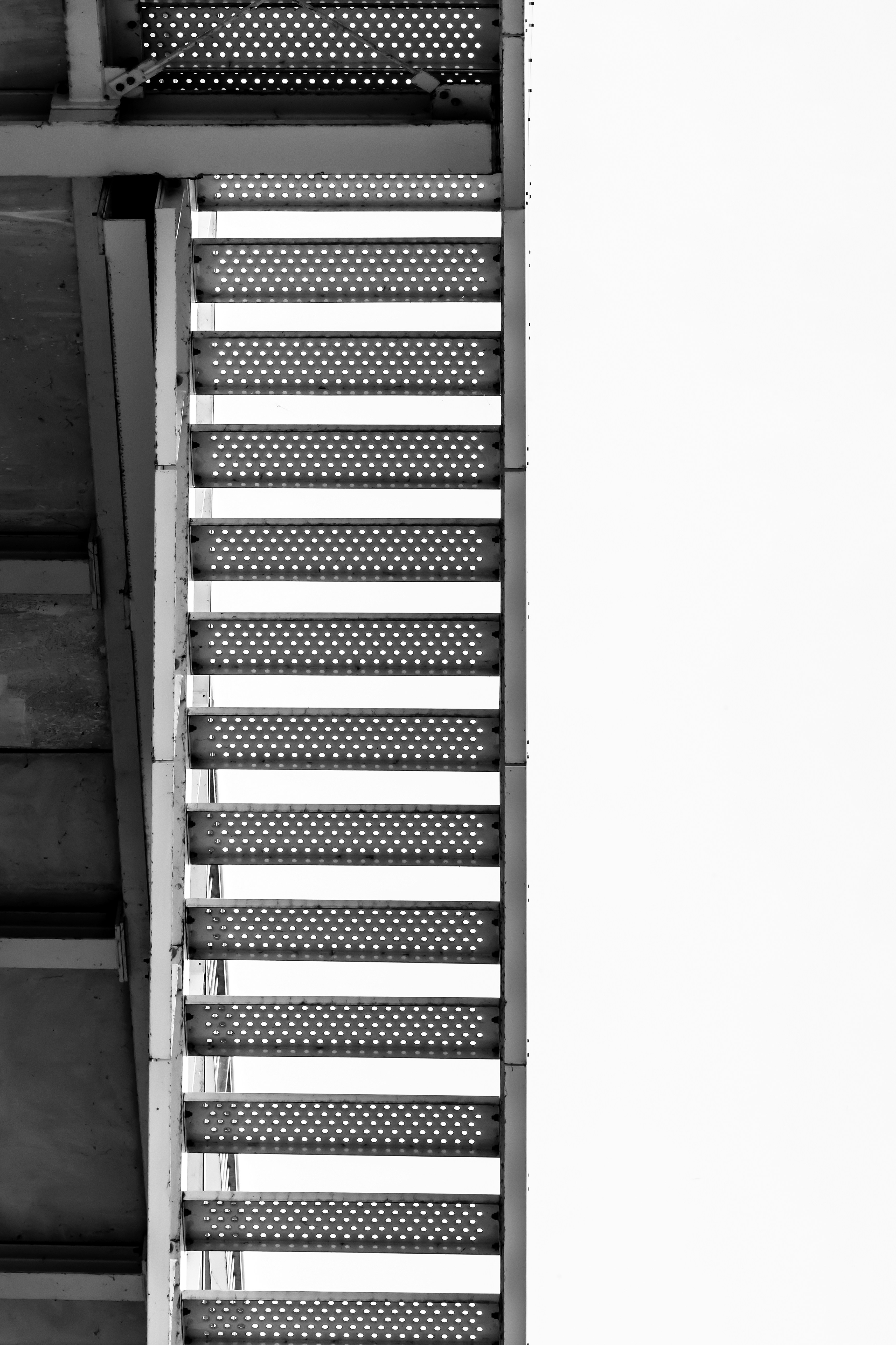Vertical Industrial Lattice: Perforated Steps in Monochrome Stack