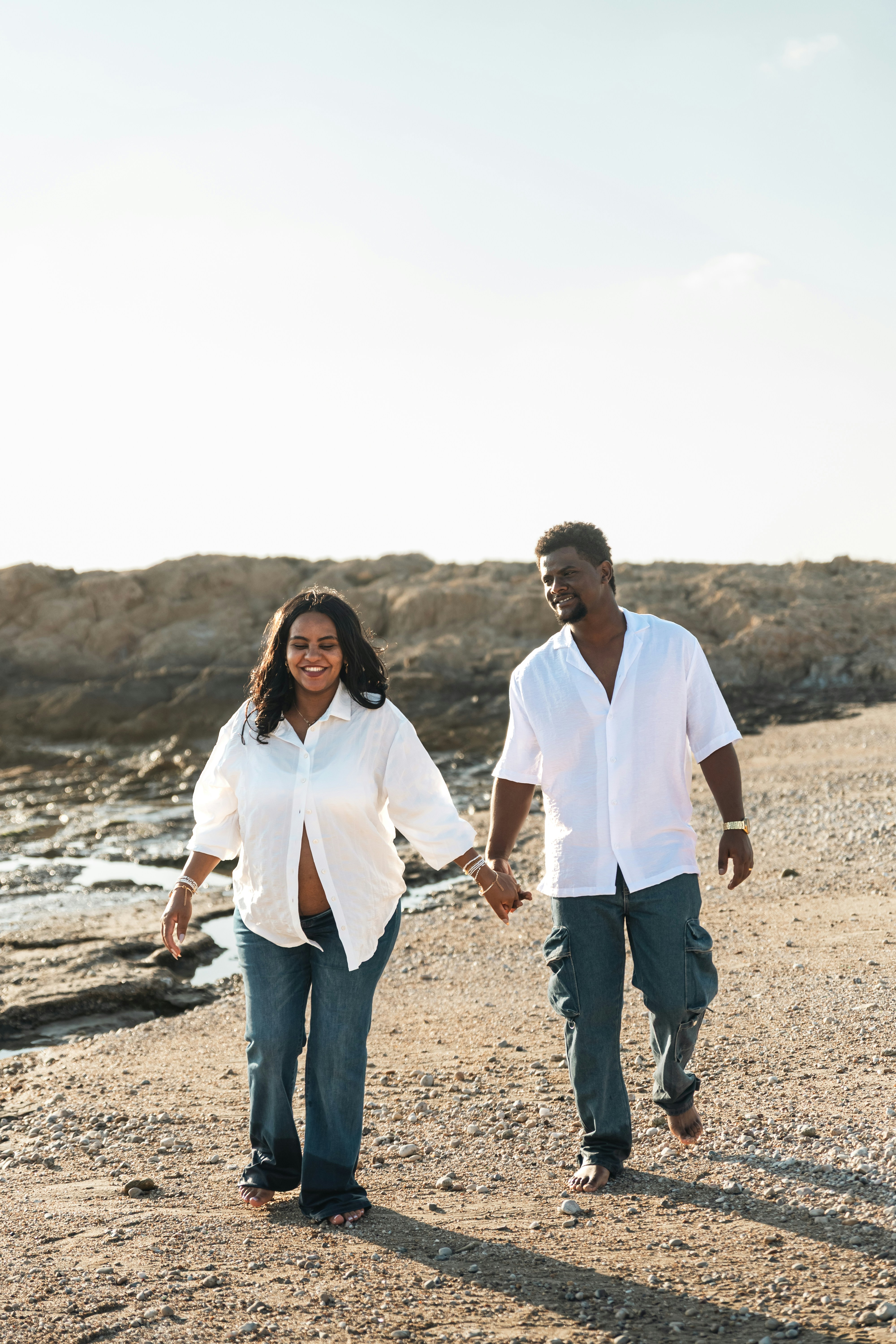 Hand in Hand on the Shoreline: A Quiet Moment in White Shirts