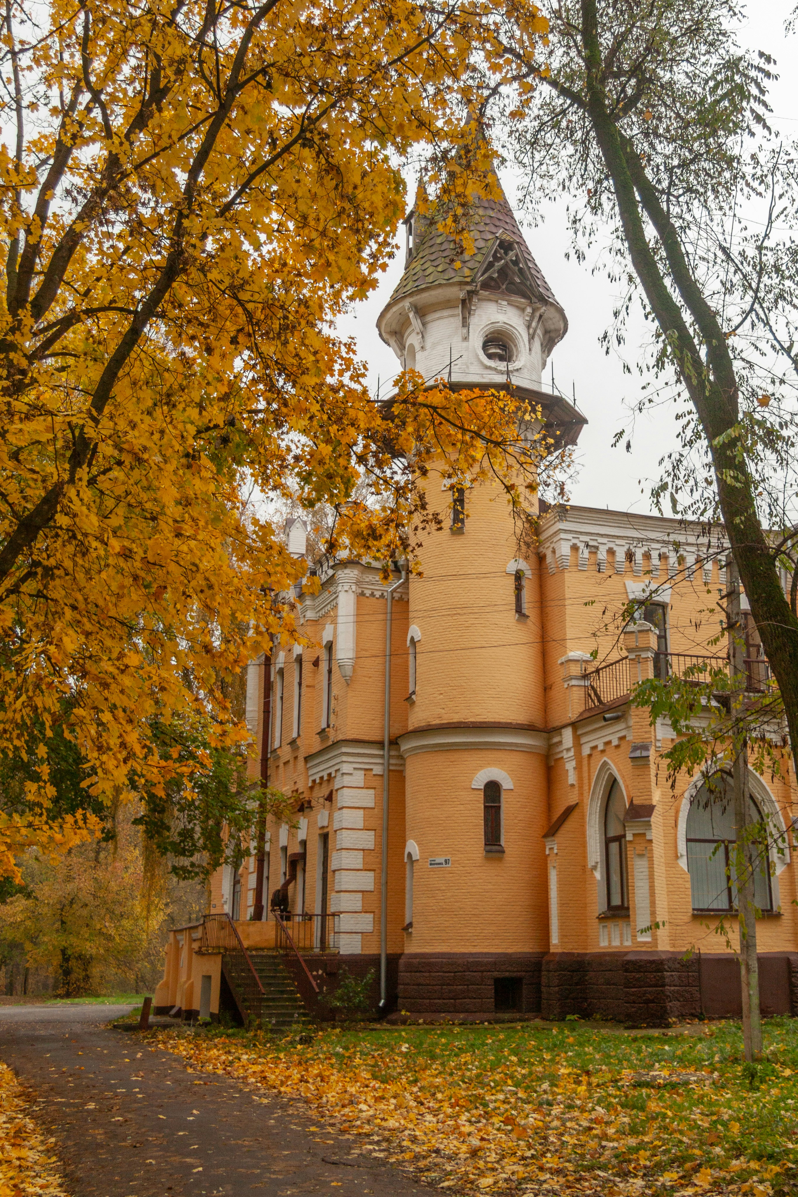 Autumn Gatehouse: A Sunlit Orange Facade Among Golden Leaves
