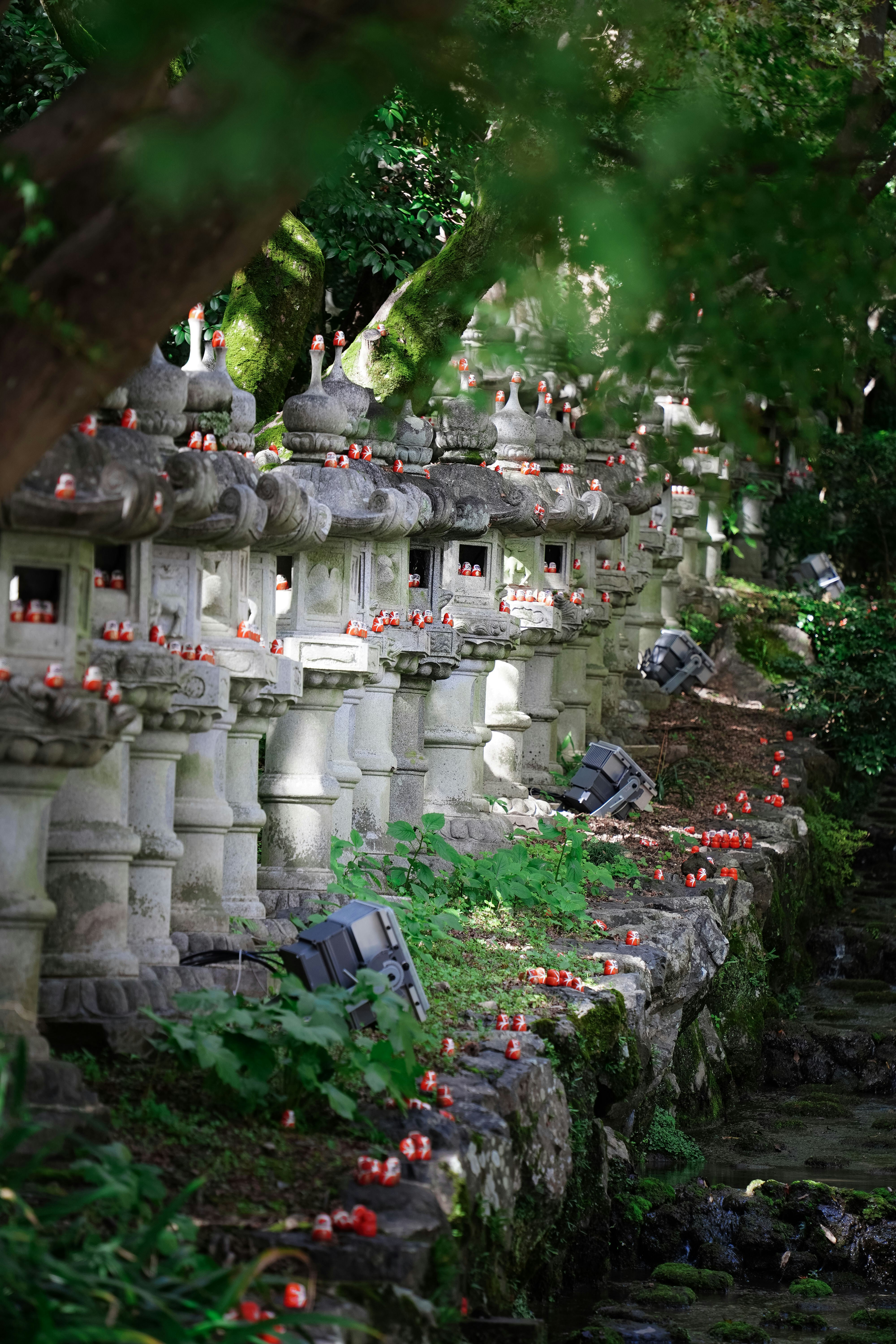 Red Candles Line the Stone Lanterns in a Serene Cemetery Path