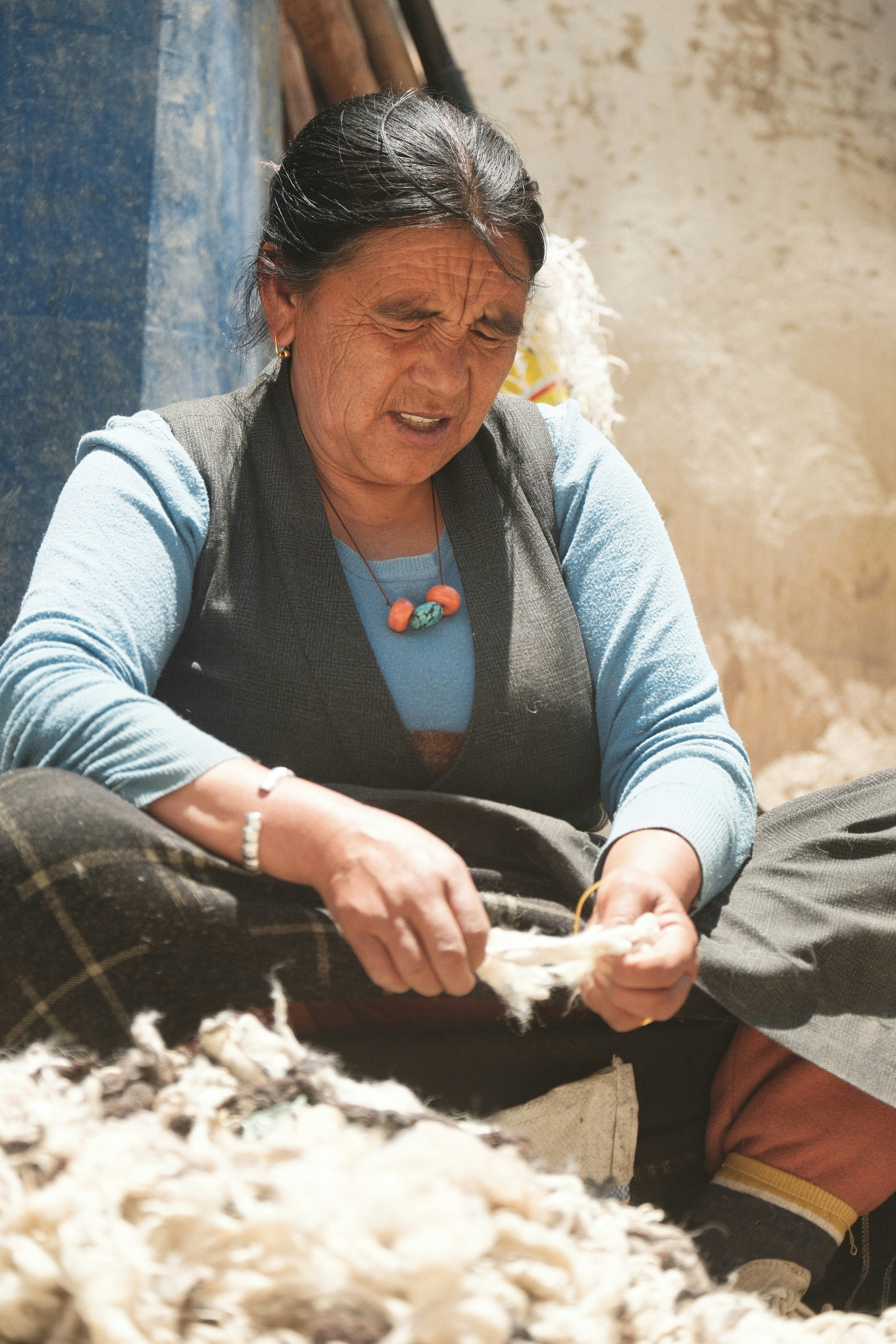 Weaving Focus: Hands Crafting Fiber Under Sunlit Wall