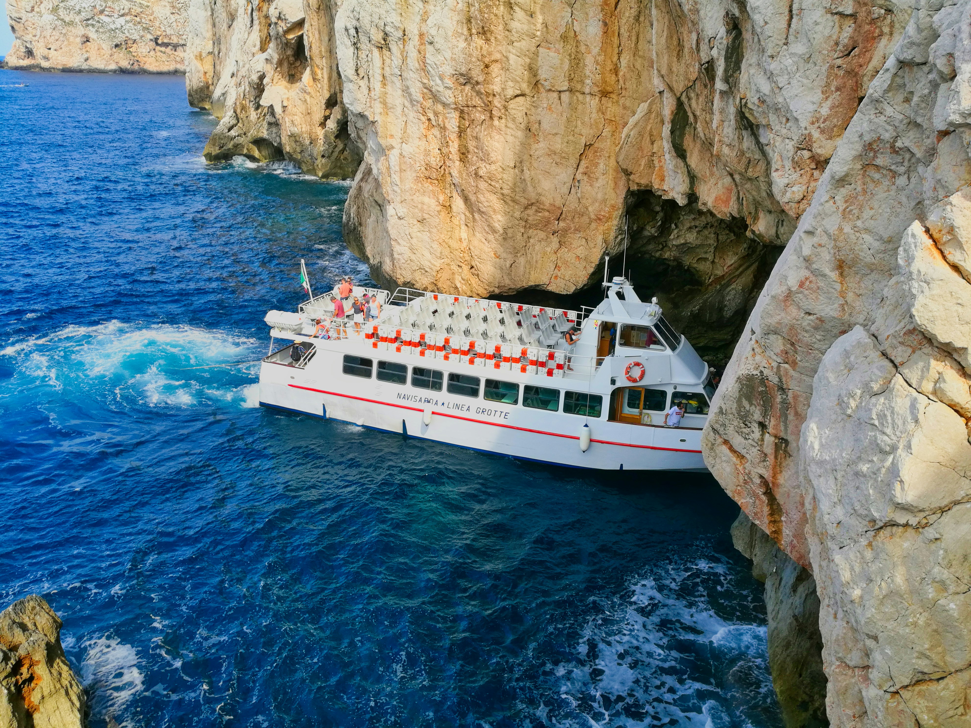 Azure Vessel Between Sea and Cliff Edges