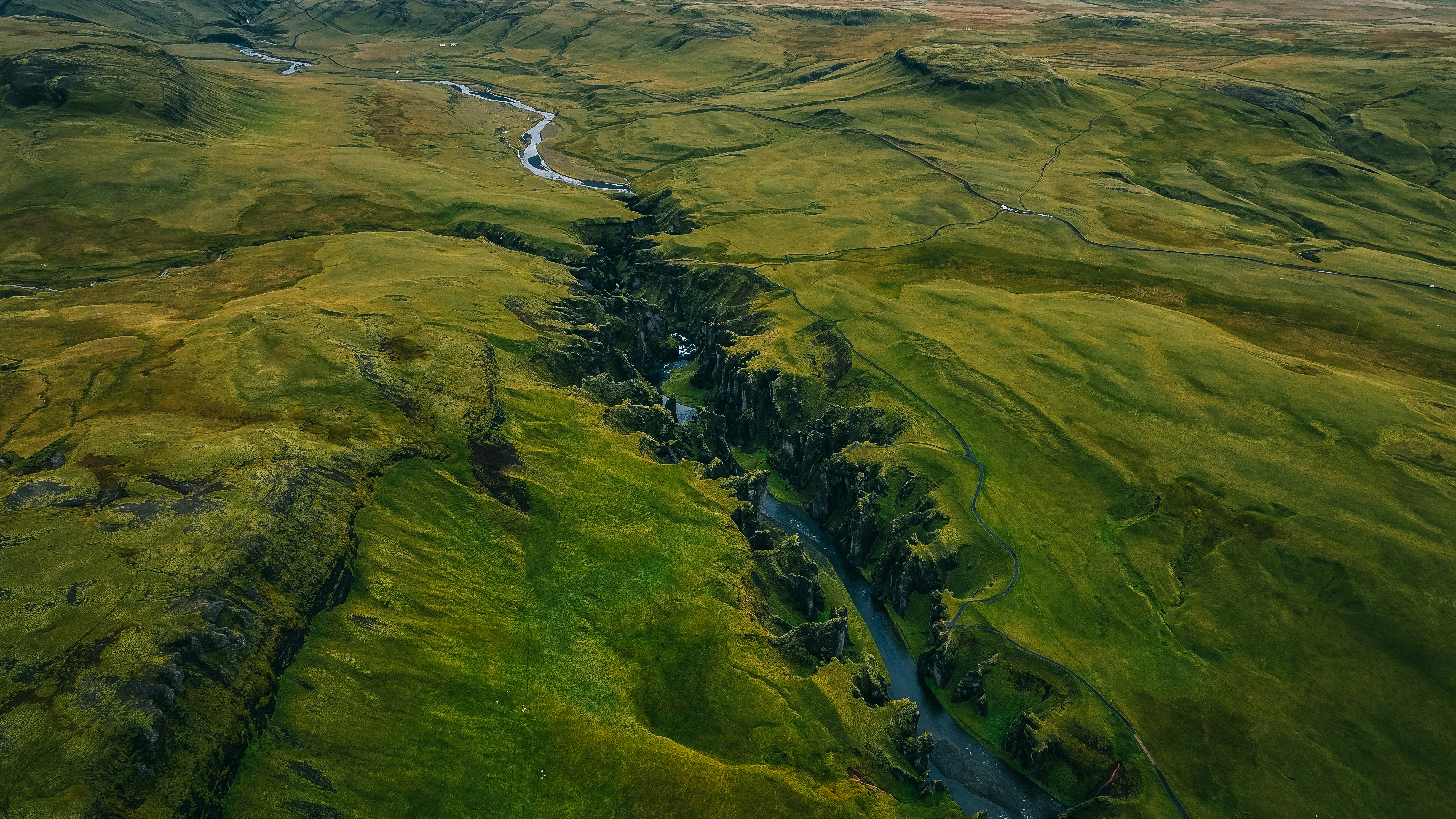 Emerald Valleys: Aerial Vein of a River Carving Through Hills